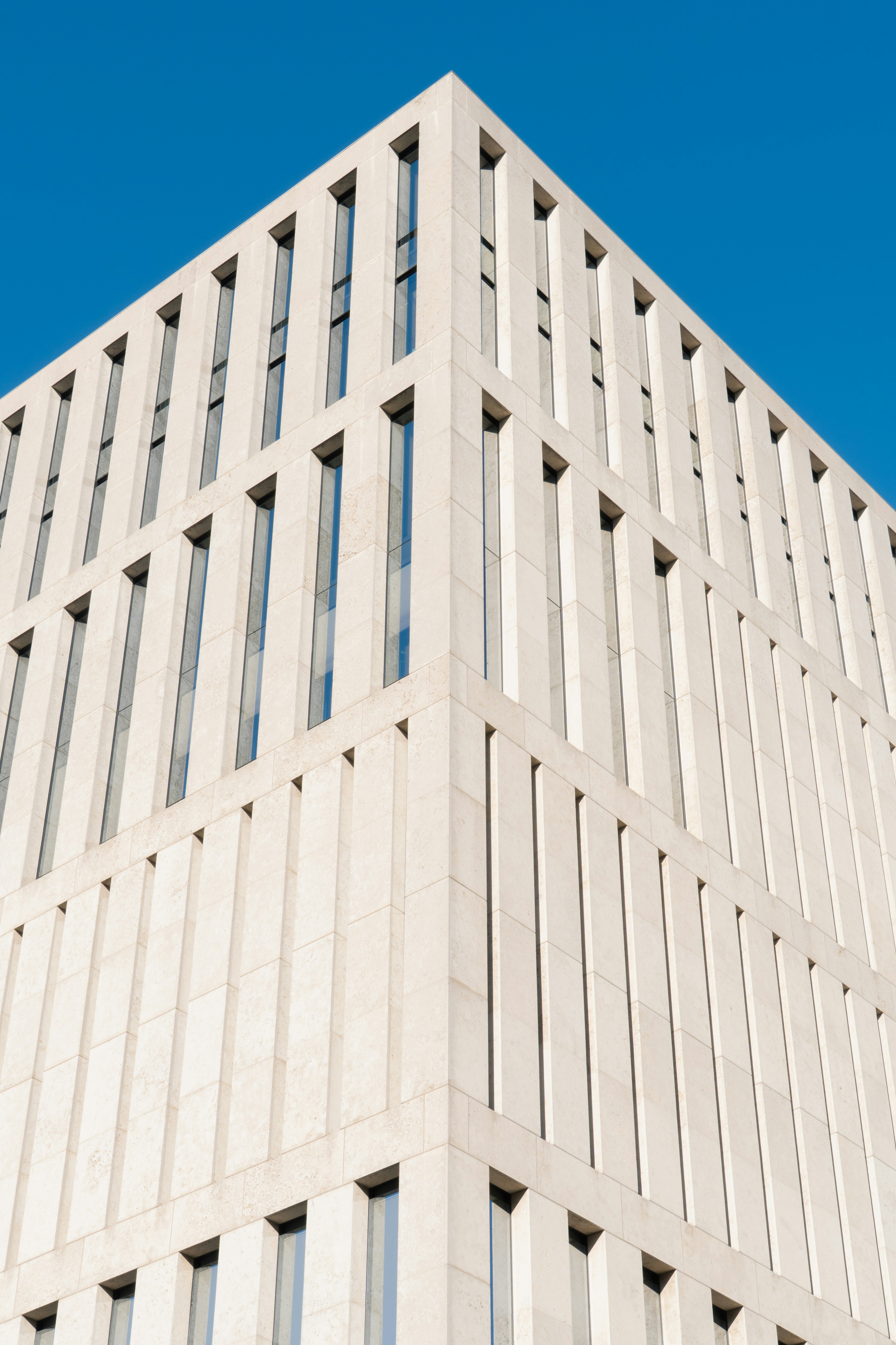 Modern architectural facade with vertical lines set against a clear blue sky.