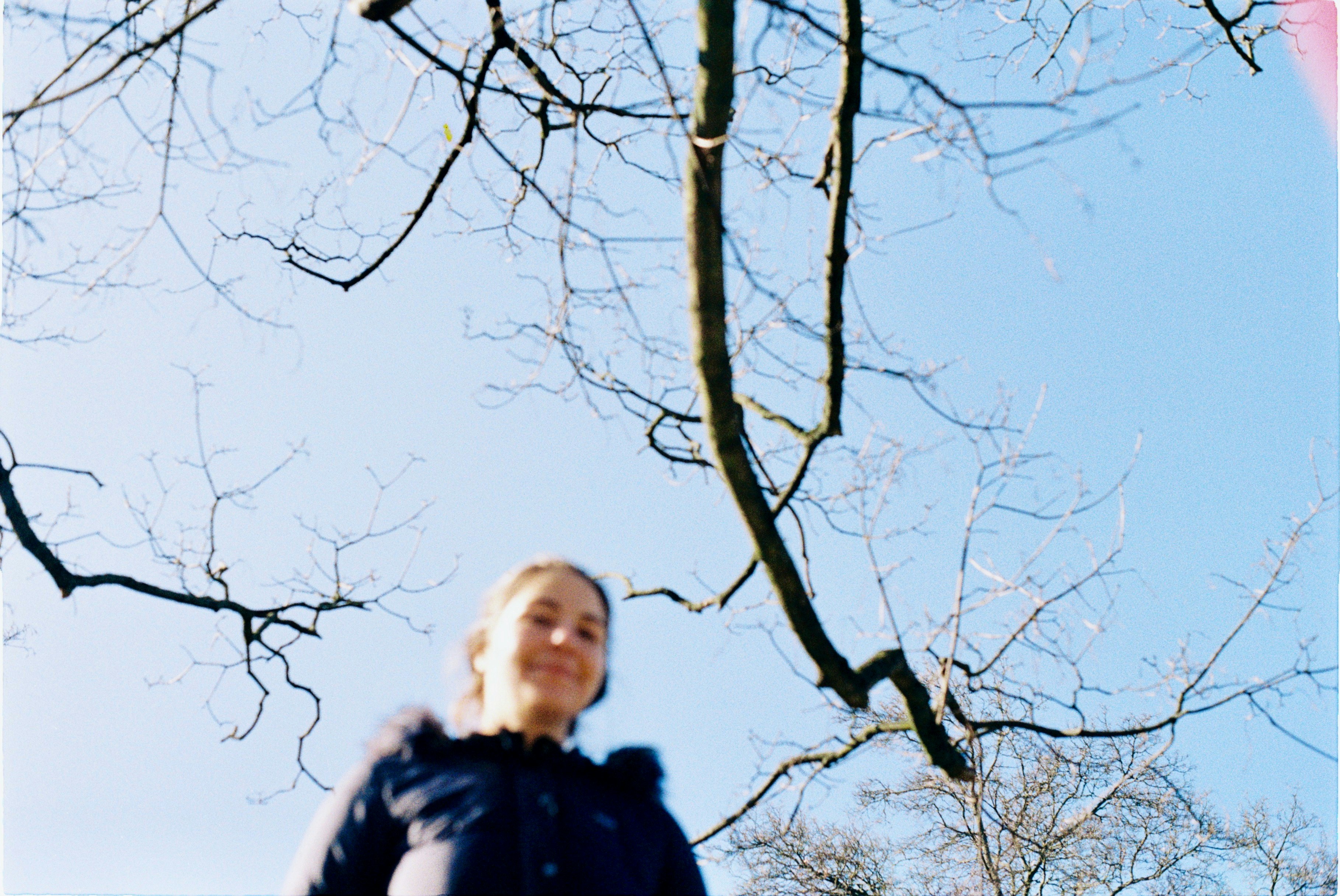 Skyward Gaze: Ground-Up Portrait Beneath Winter Branches