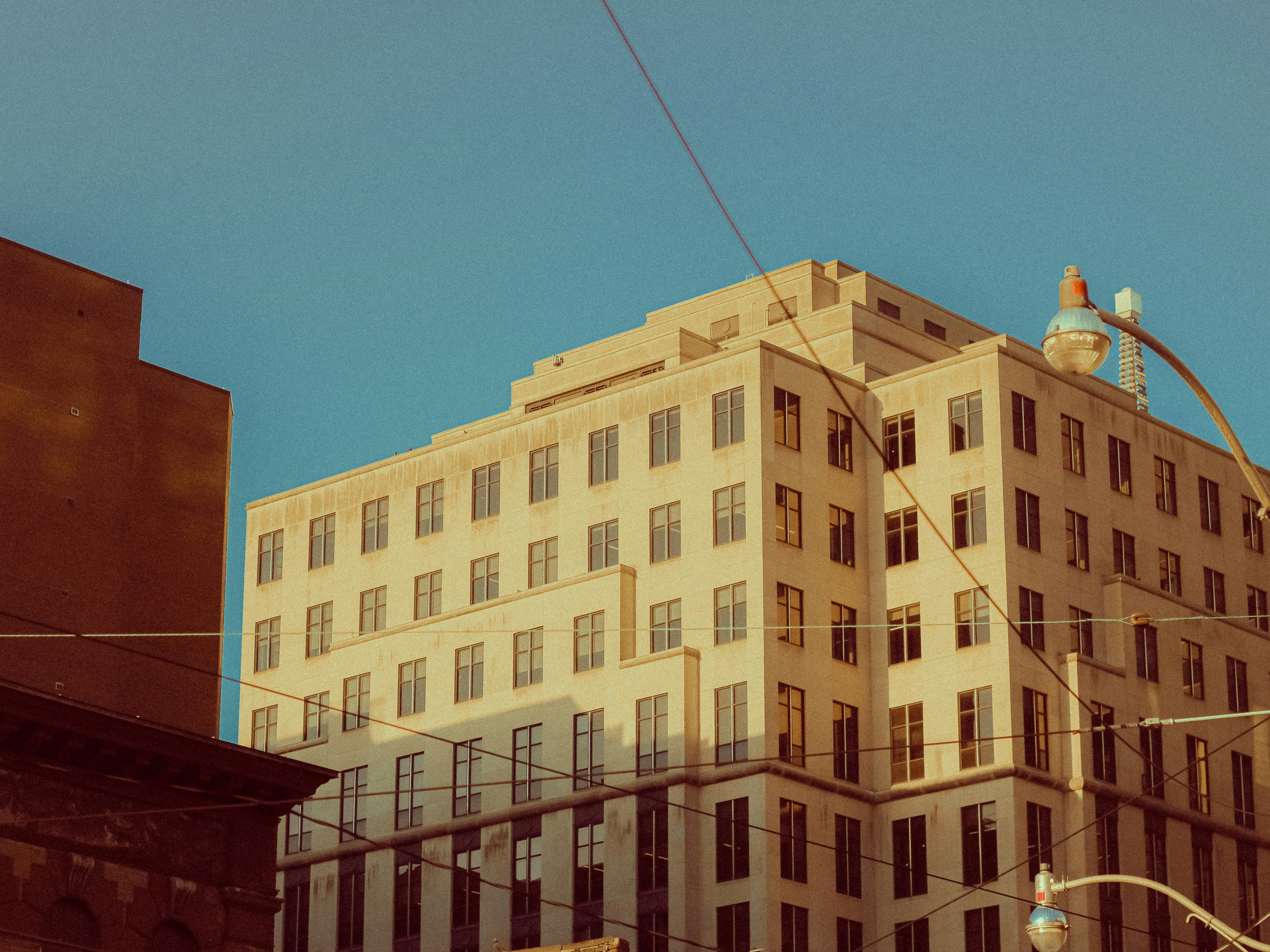 A tall building stands under a blue sky. photo – Free Building Image on ...