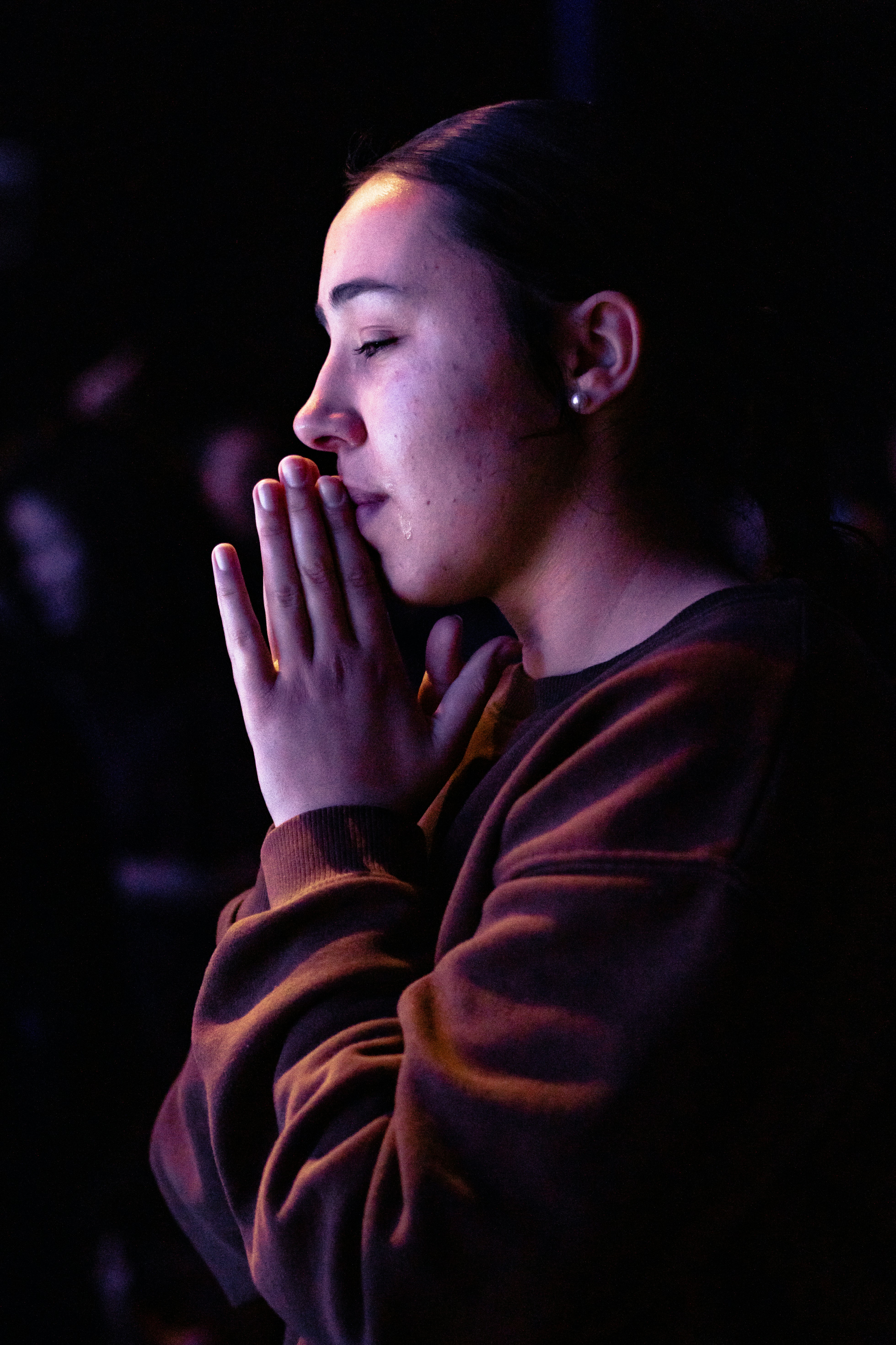 Woman bows head in prayer with hands clasped. photo – Free Portrait ...