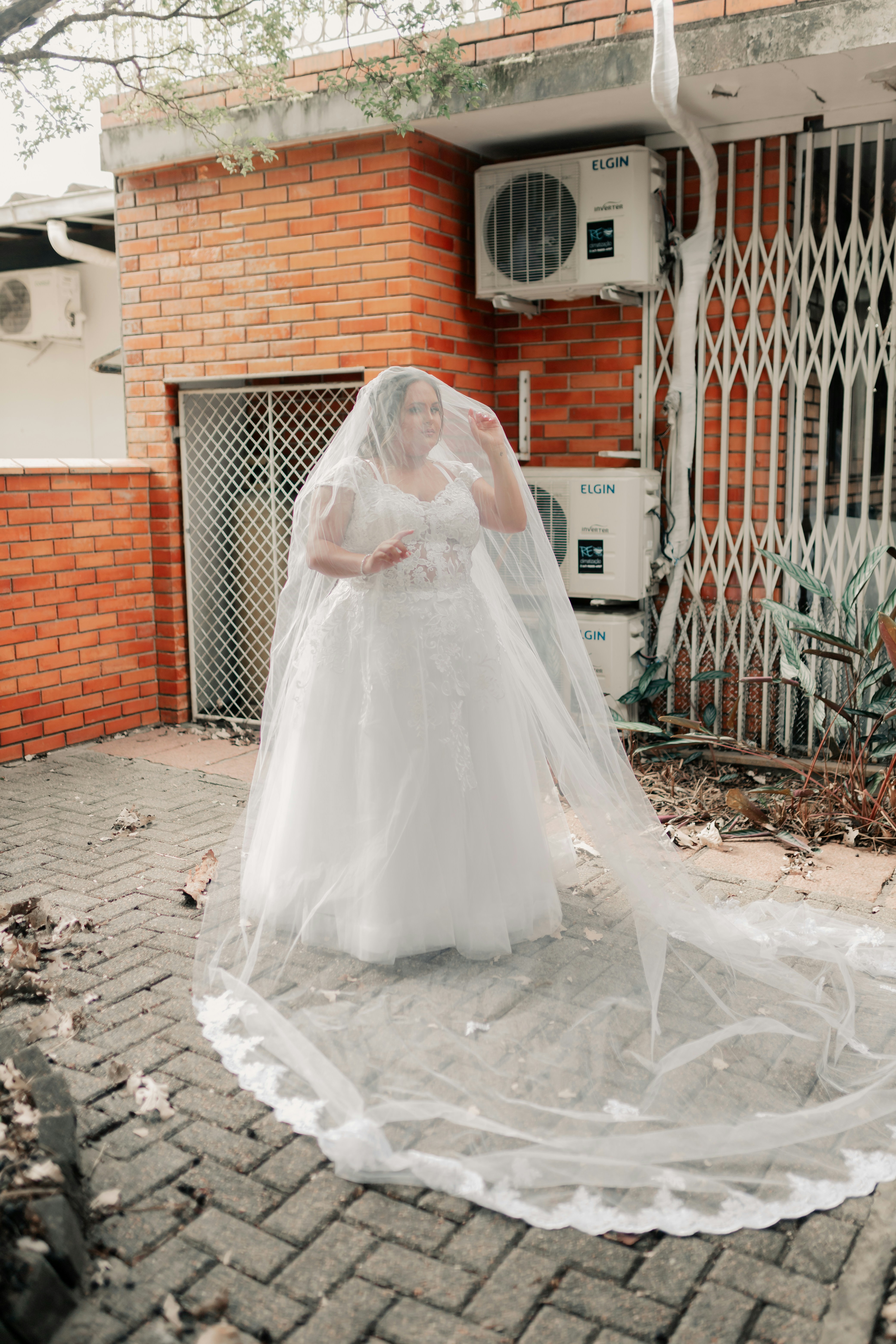 Veil in the Brick Courtyard: A Bride Amid Lace and Light