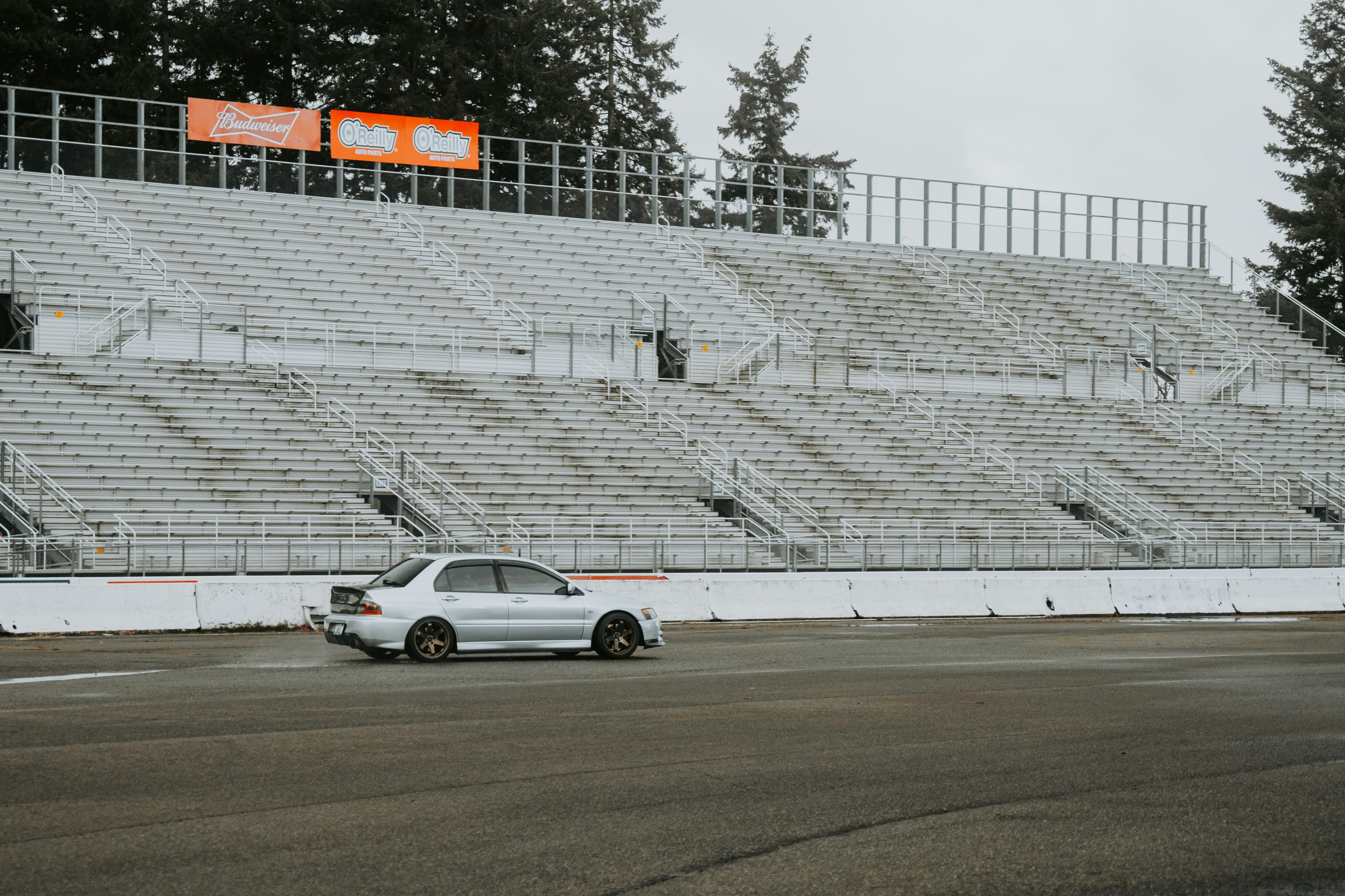 A car drives on a racetrack with empty stands. photo – Free Car Image ...