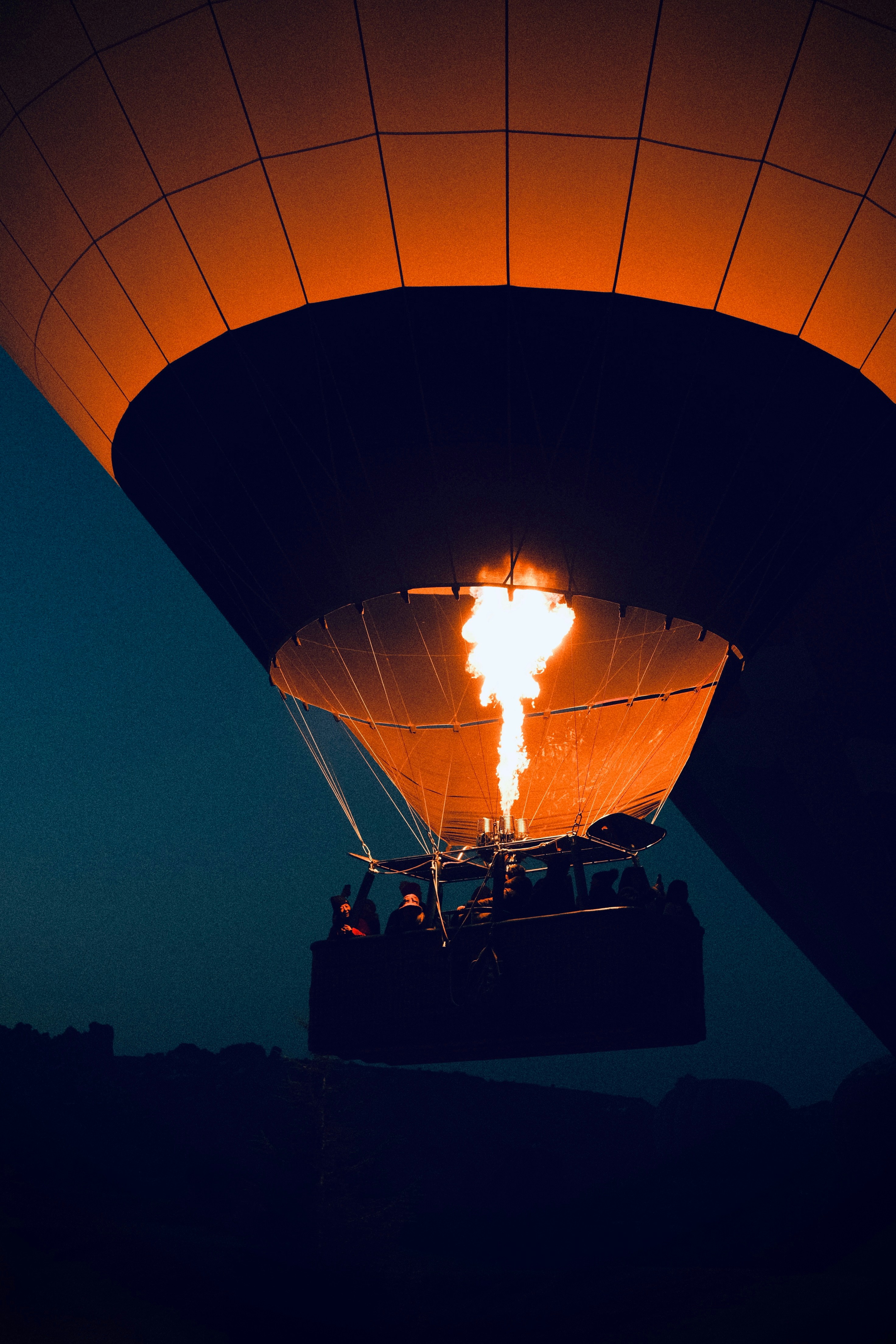 Night Ascent: The Flame Illuminating a Balloon Against the Dark Sky