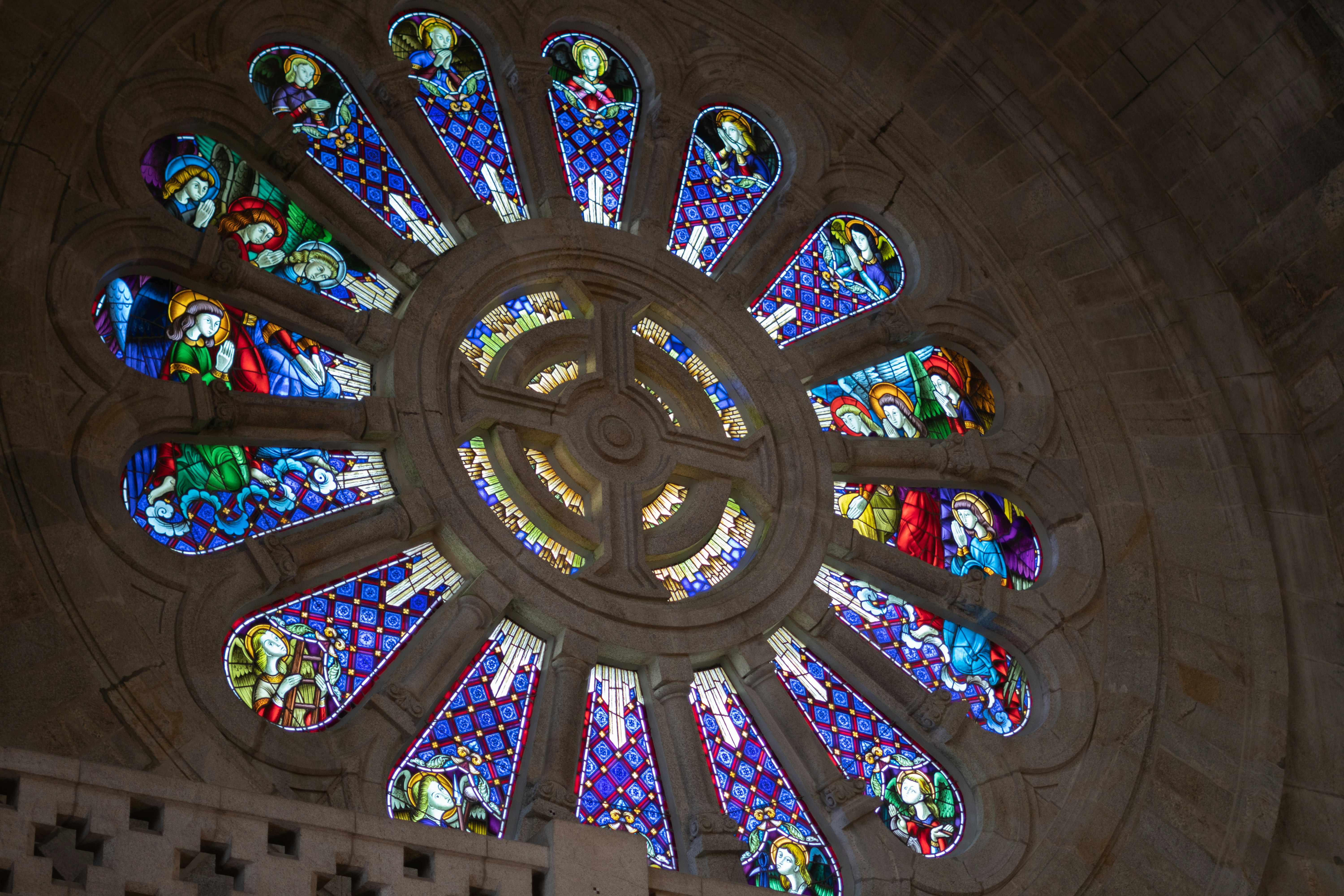 Colorful stained glass rose window casting vibrant patterns inside a stone structure.