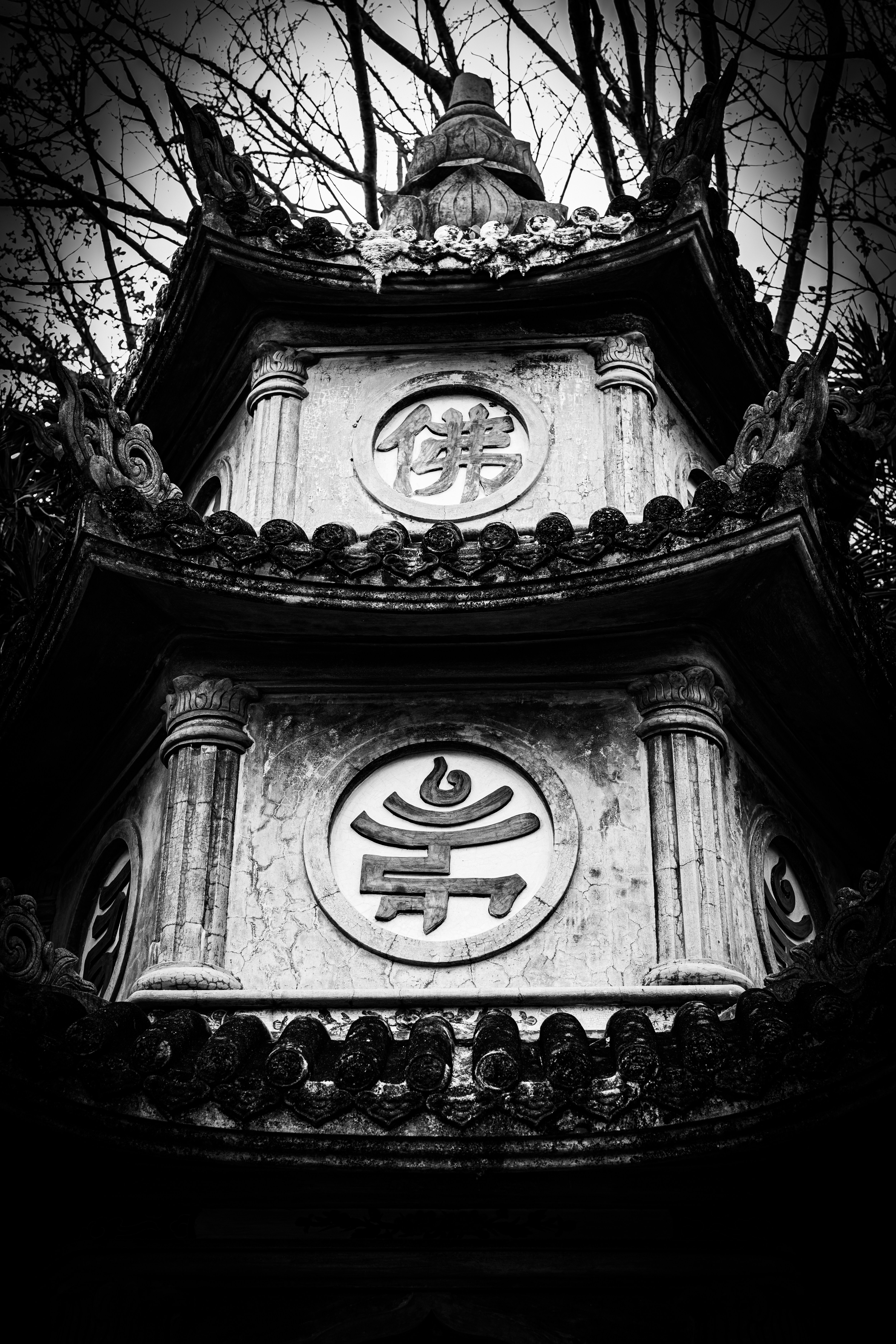 Glyphs in the Gloom: A Monochrome Pagoda with Circular Emblems