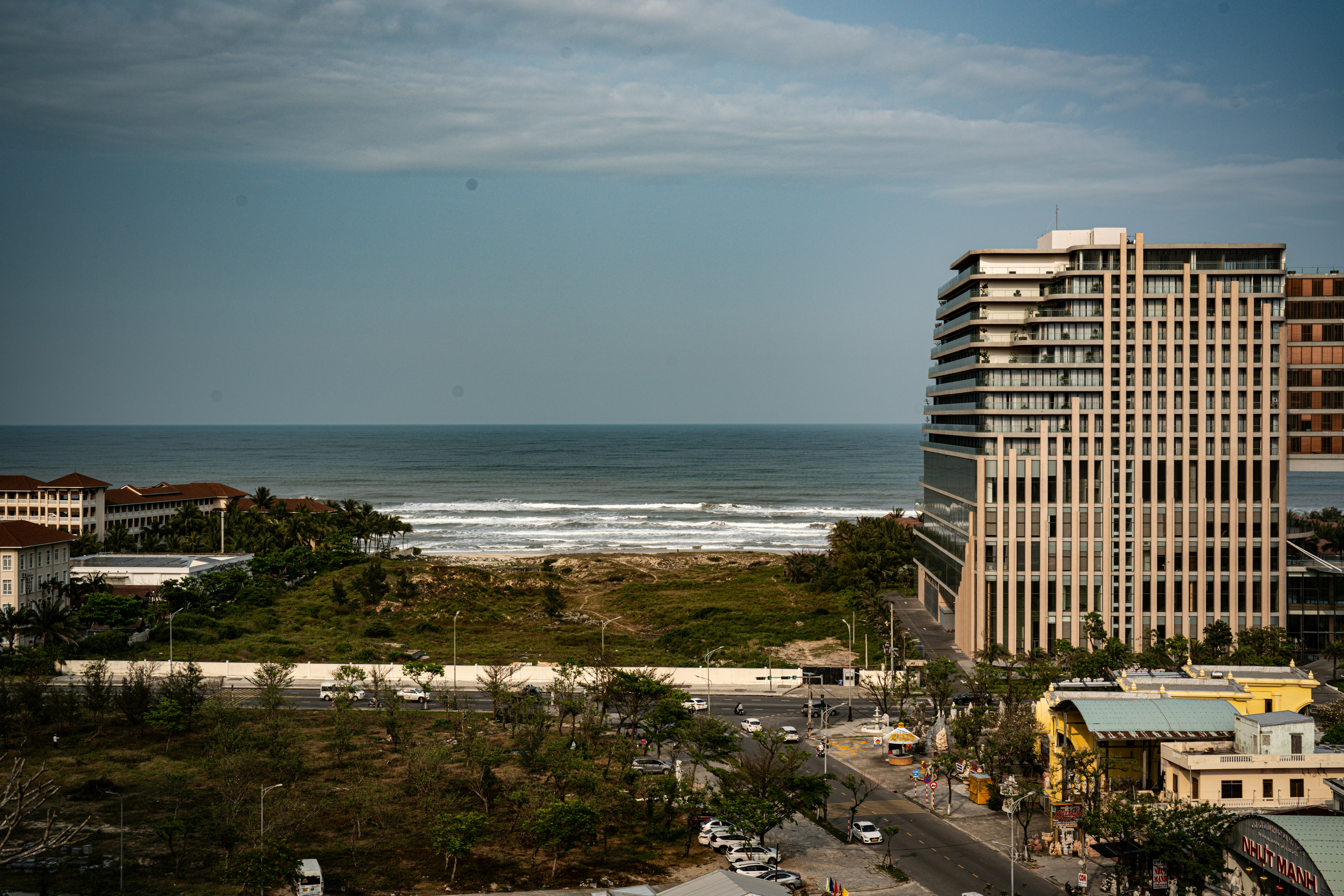 Beachfront city buildings overlook a wavy ocean. photo – Free City ...