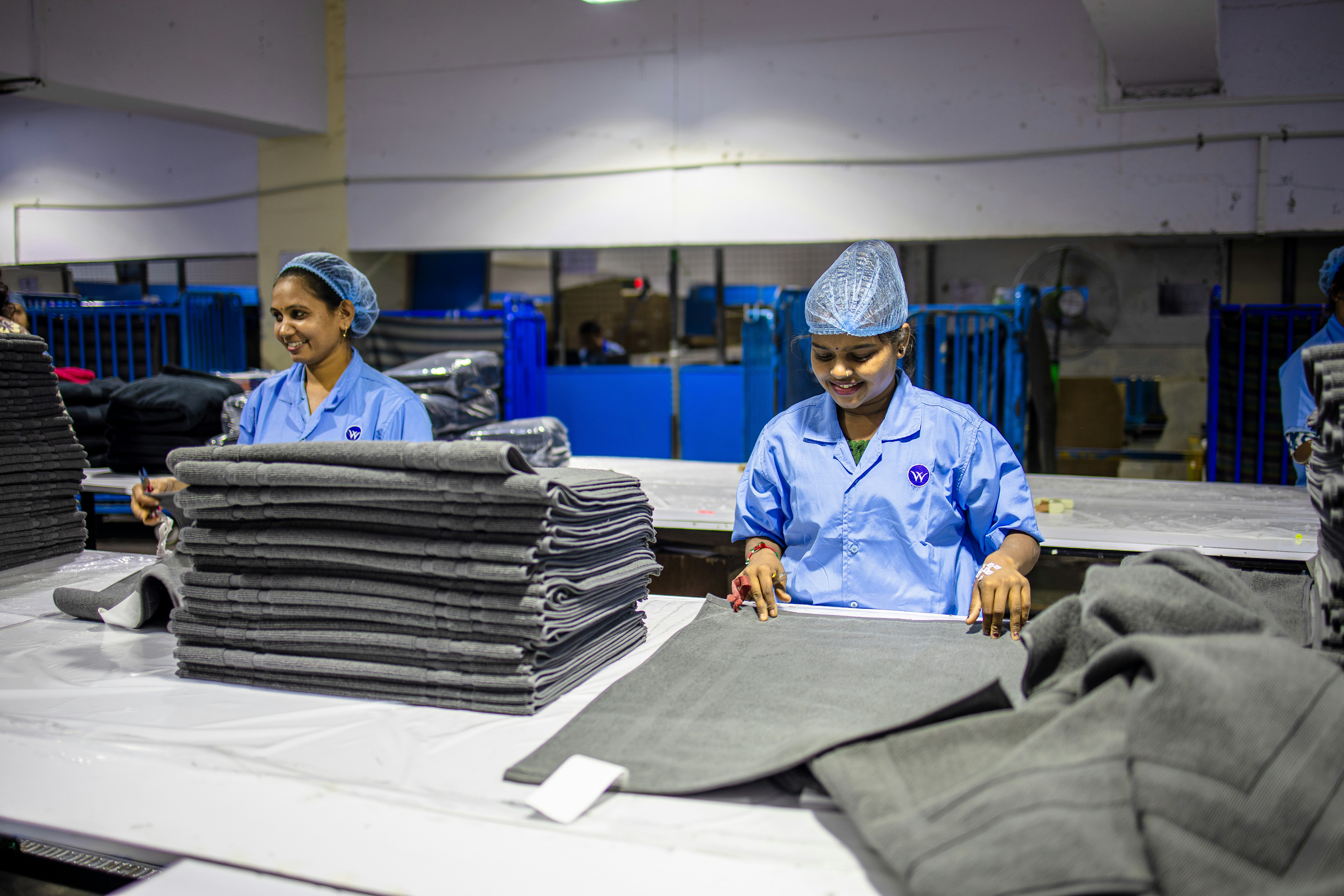 Workers folding textiles in a factory. photo – Free Woman Image on Unsplash