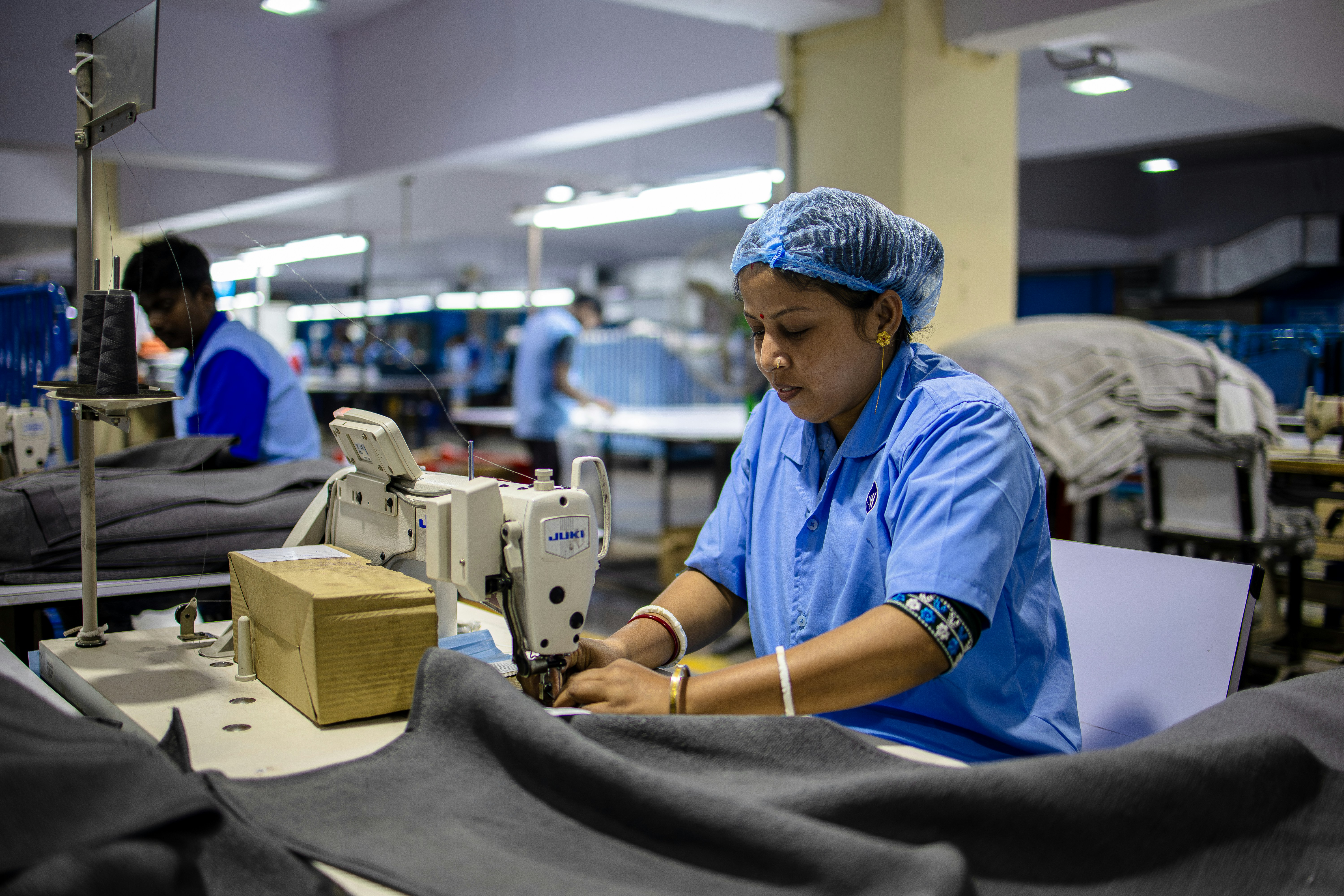 Woman operates sewing machine in a textile factory. photo – Free Human ...