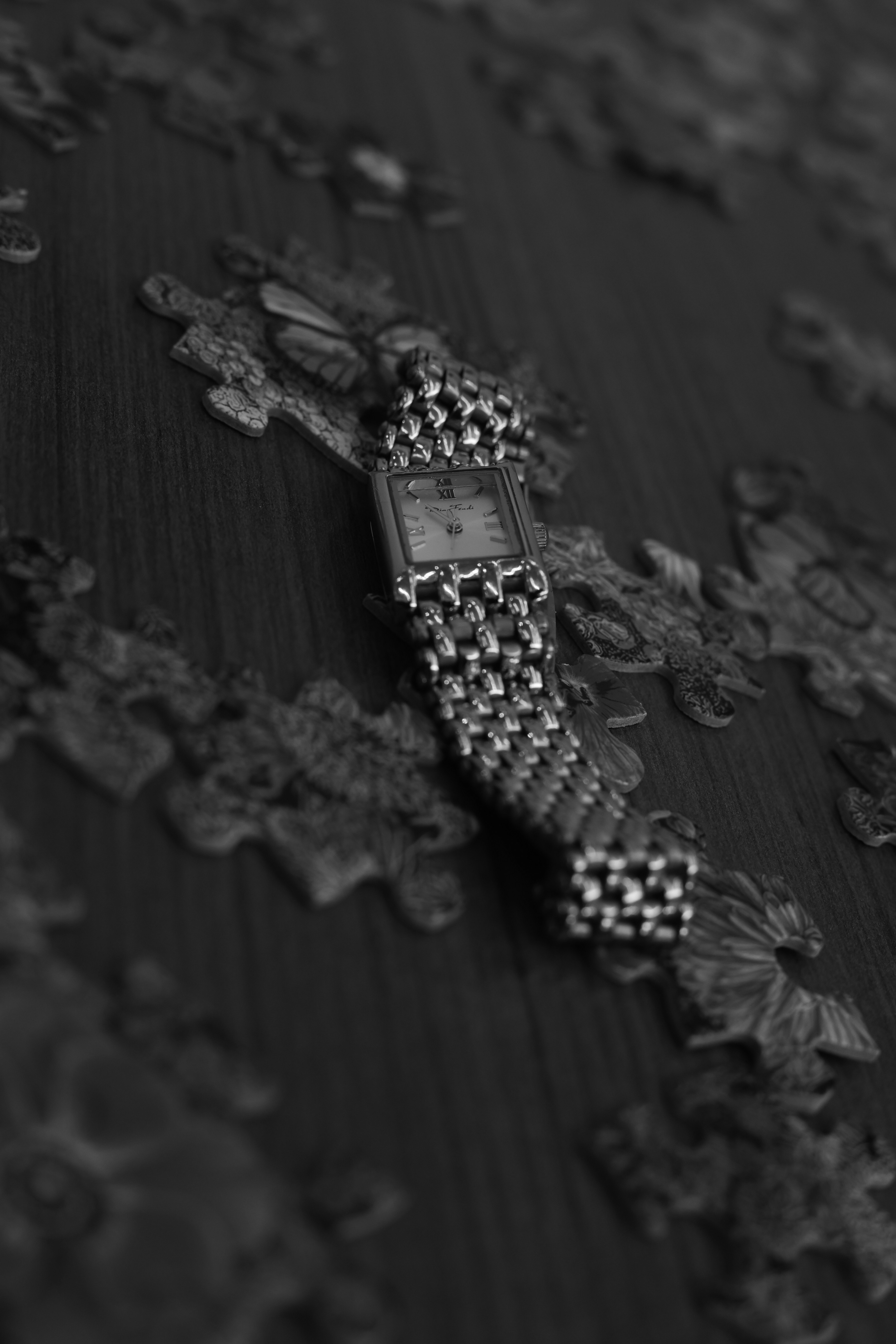 Timepiece in a Field of Petals: a silver watch rests among scattered floral confetti