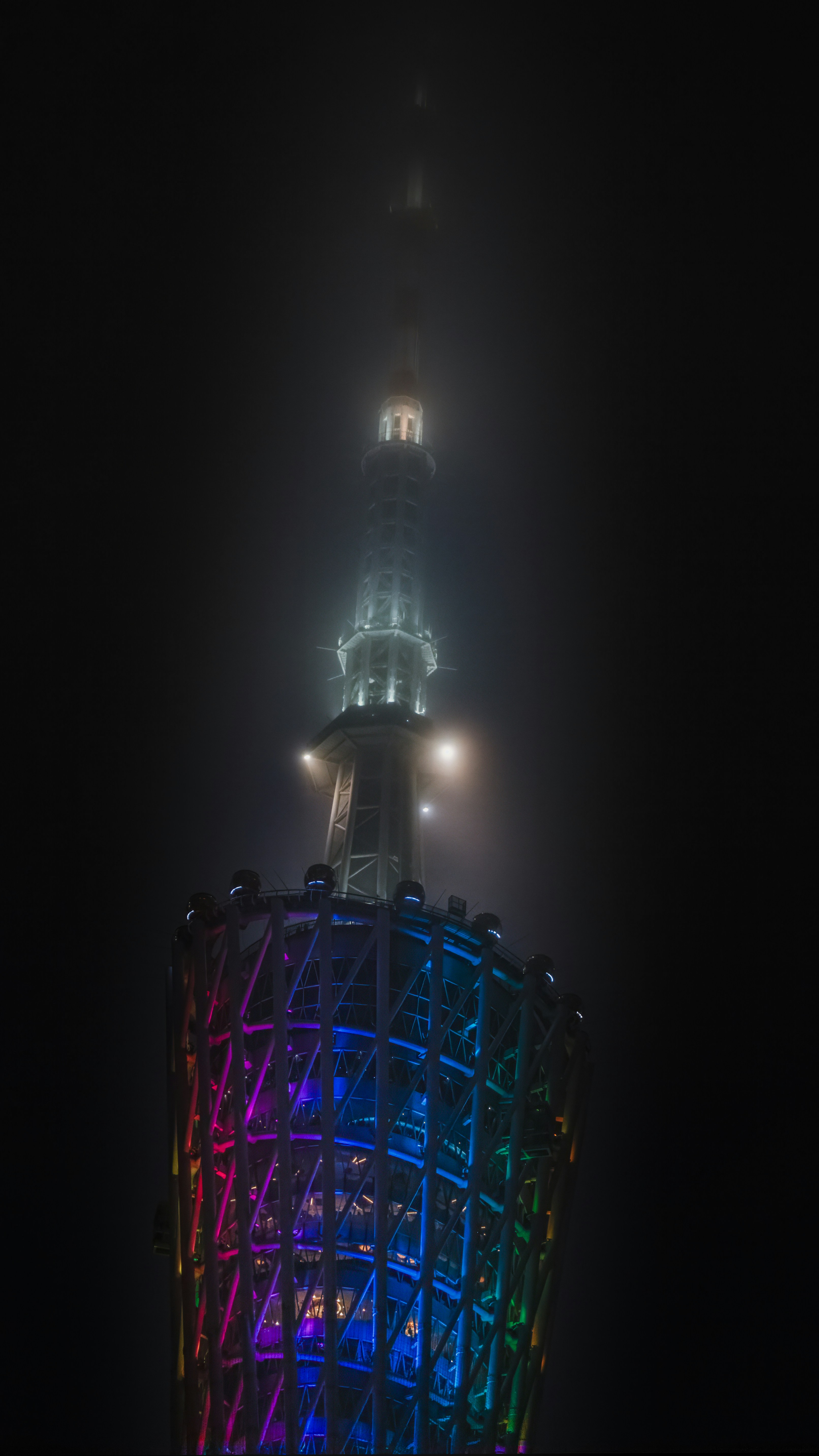 A tall, colorful tower shrouded in fog. photo – Free Moon Image on Unsplash