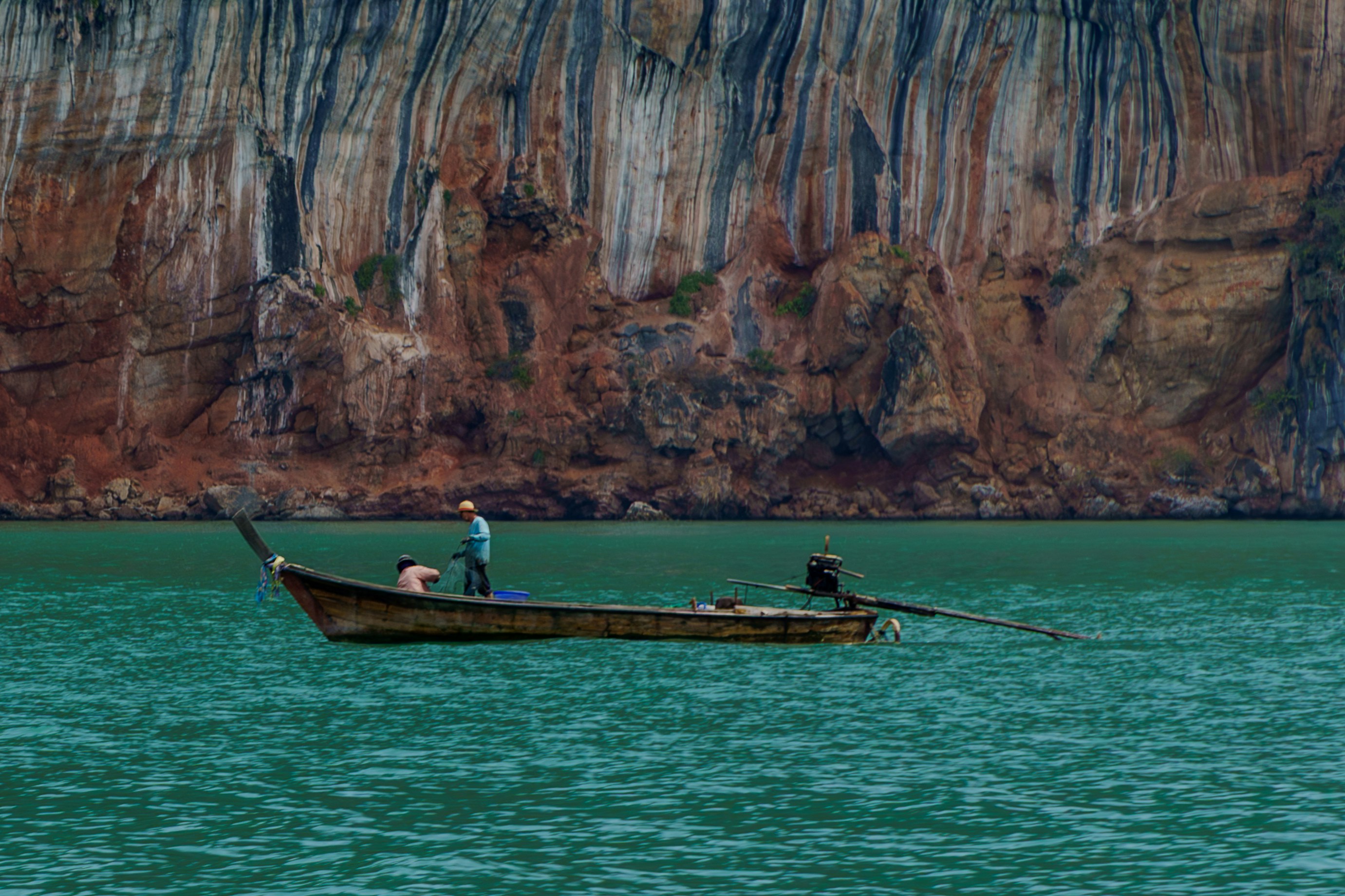 A boat sails near a striking cliff. photo – Free Sea Image on Unsplash