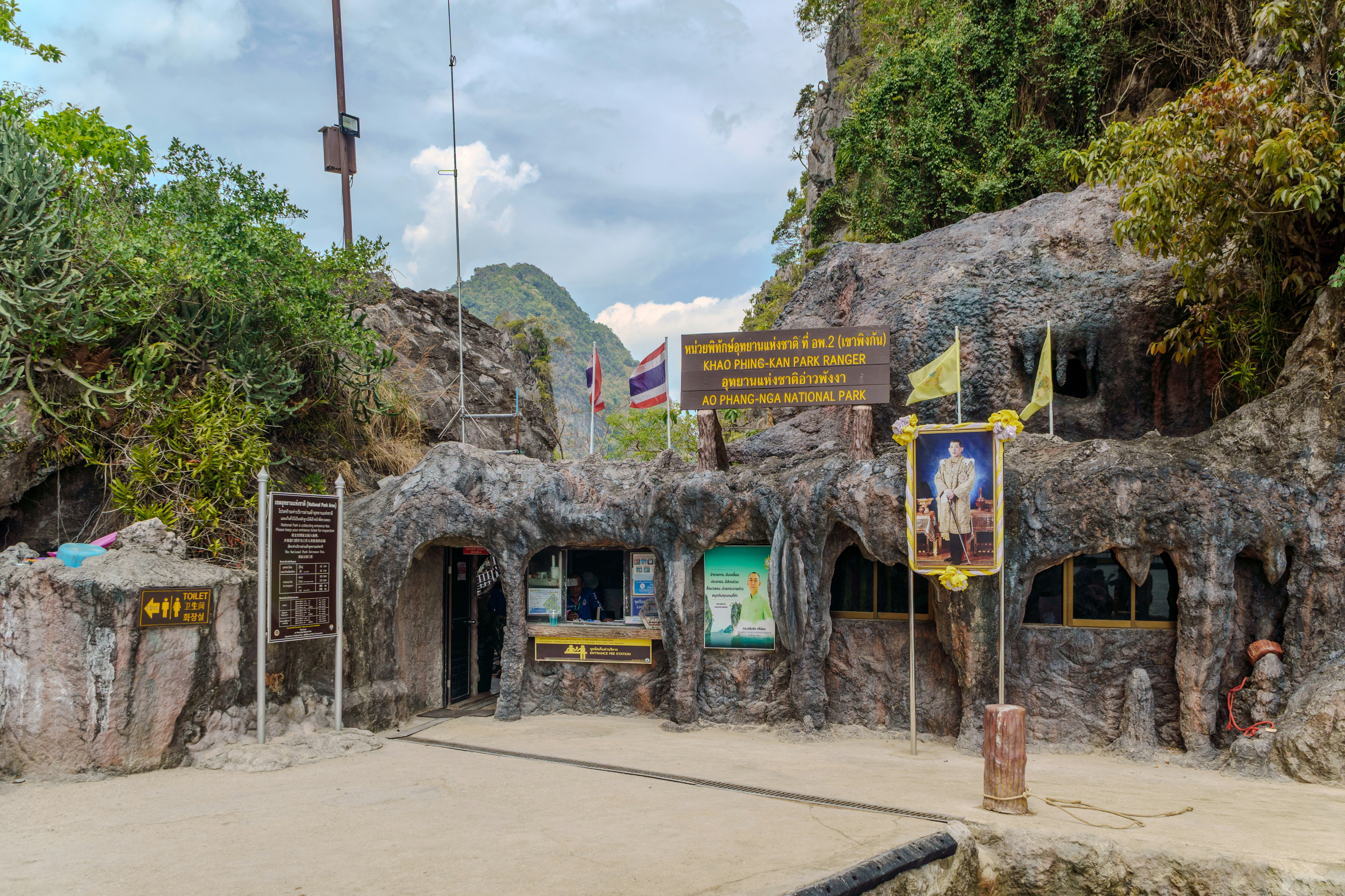 Cave entrance with signs and flags. photo – Free Human Image on Unsplash