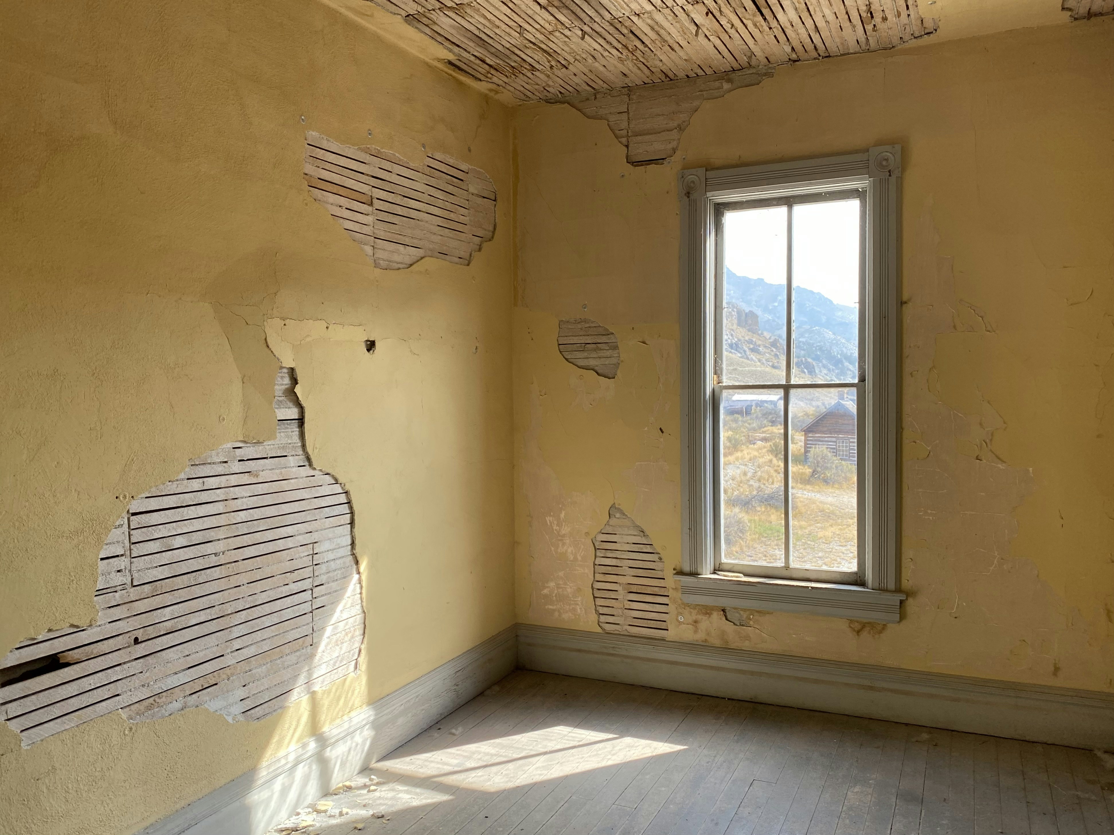 Patchwork Light: A Sunlit Window Framing a Worn Yellow Room