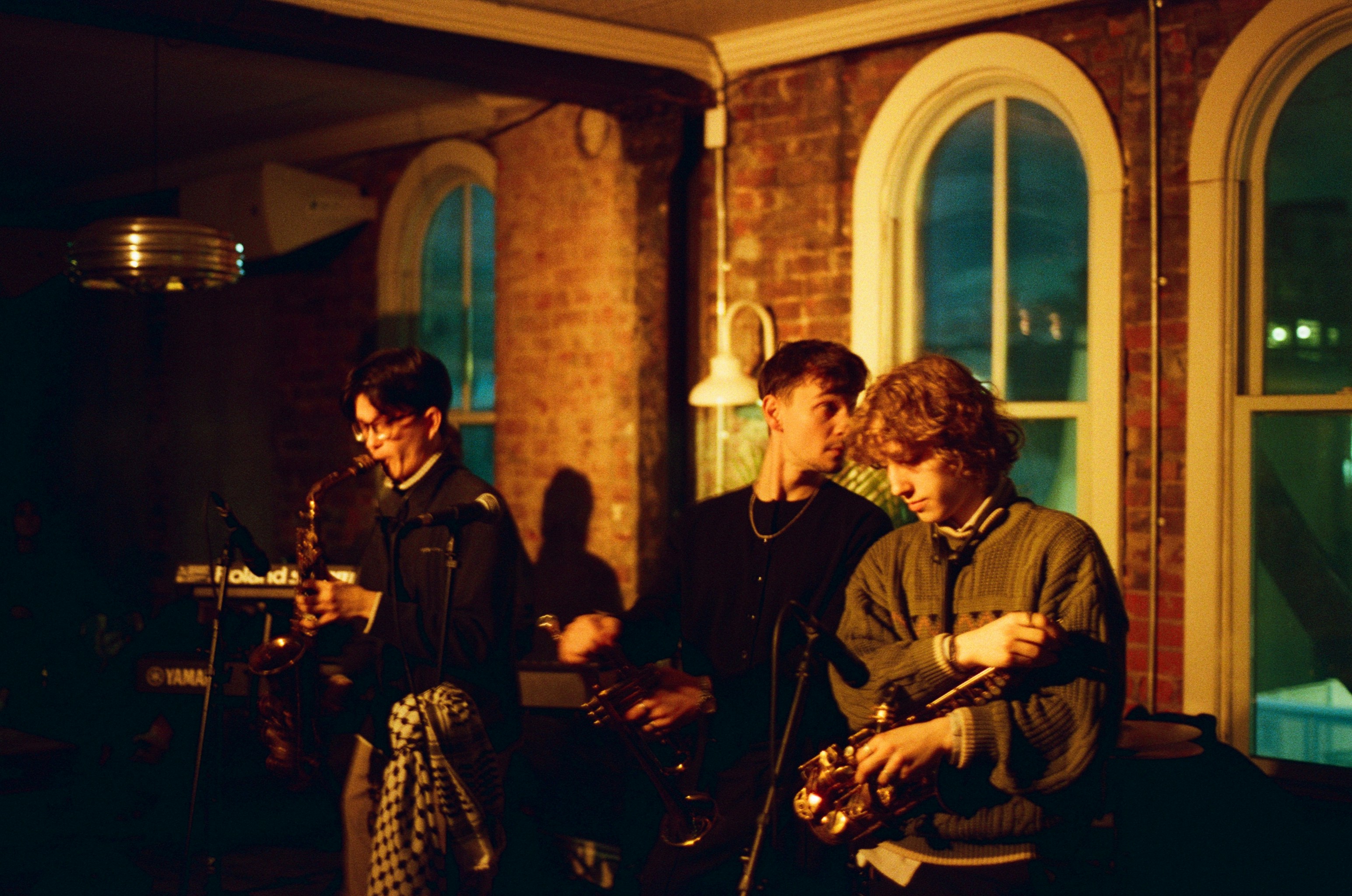 A band performs on a dimly lit stage. photo – Free Portrait Image on ...