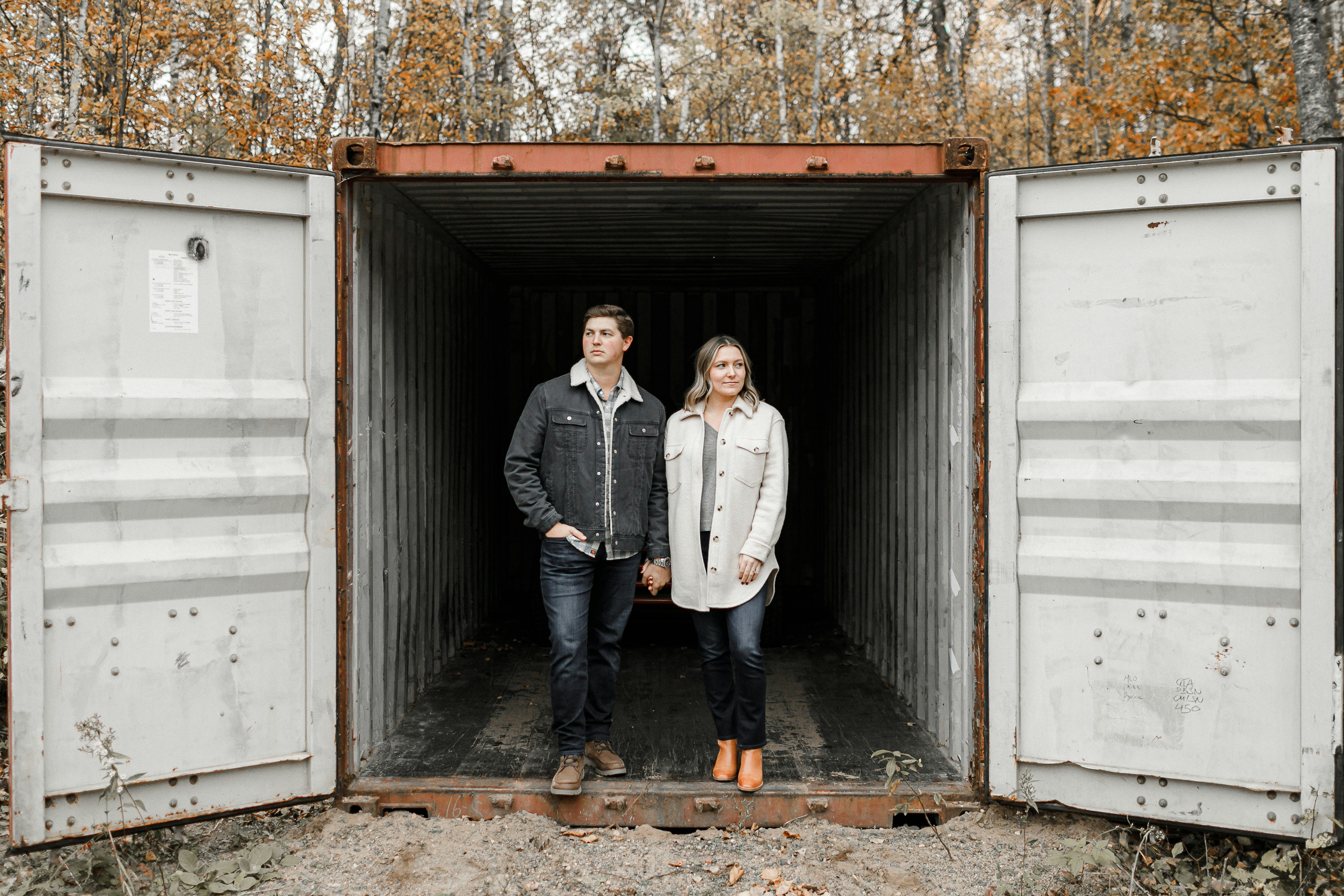 A couple stands inside an open shipping container. photo – Free Man ...