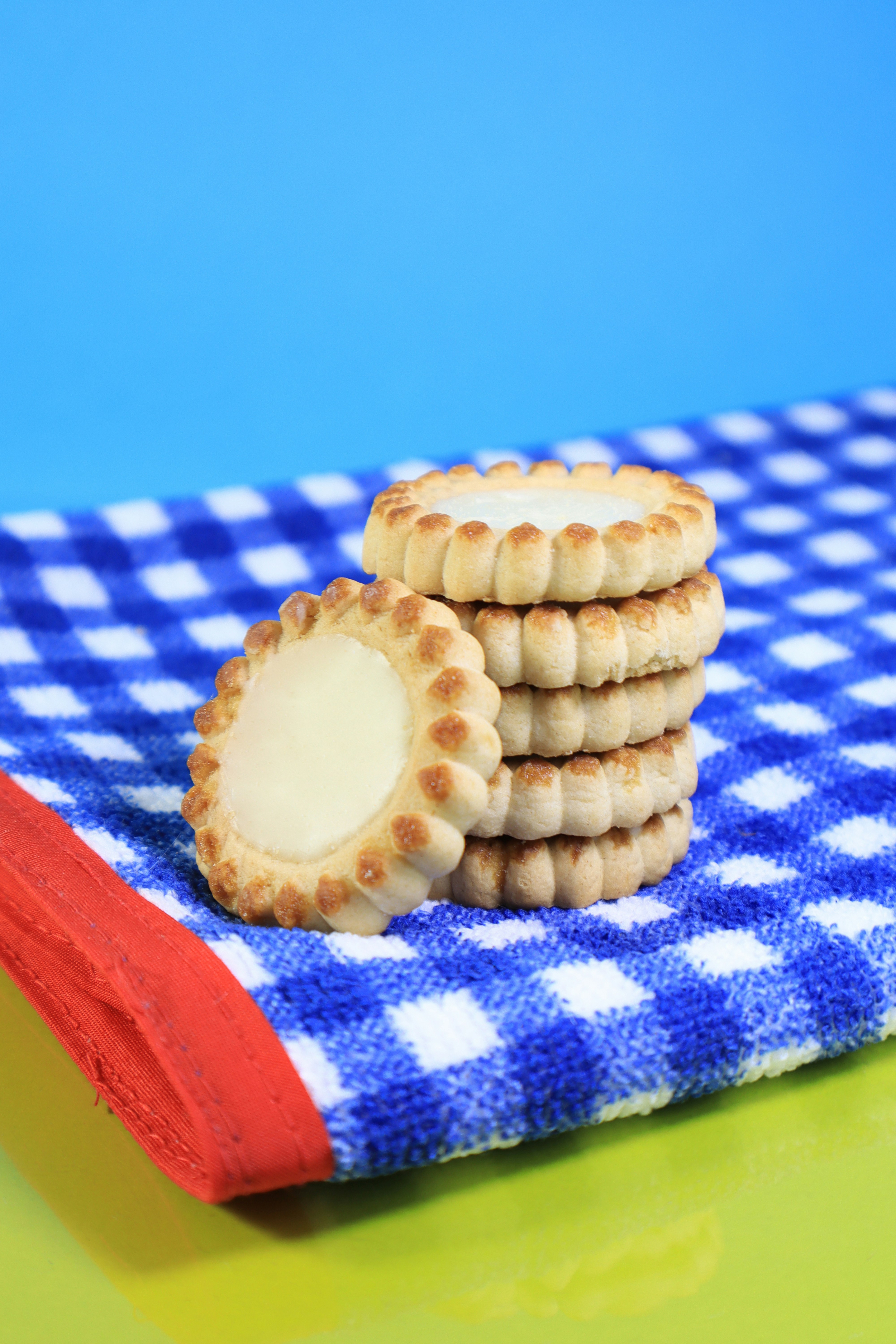 Cream-Filled Ring Cookies Stacked on a Blue Checkered Cloth
