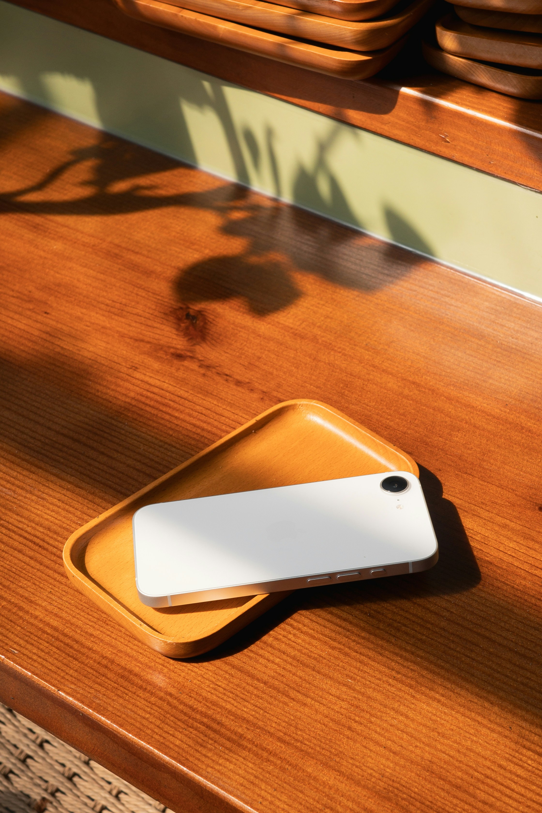 A phone rests on a small wooden tray. photo – Free Iphone Image on Unsplash