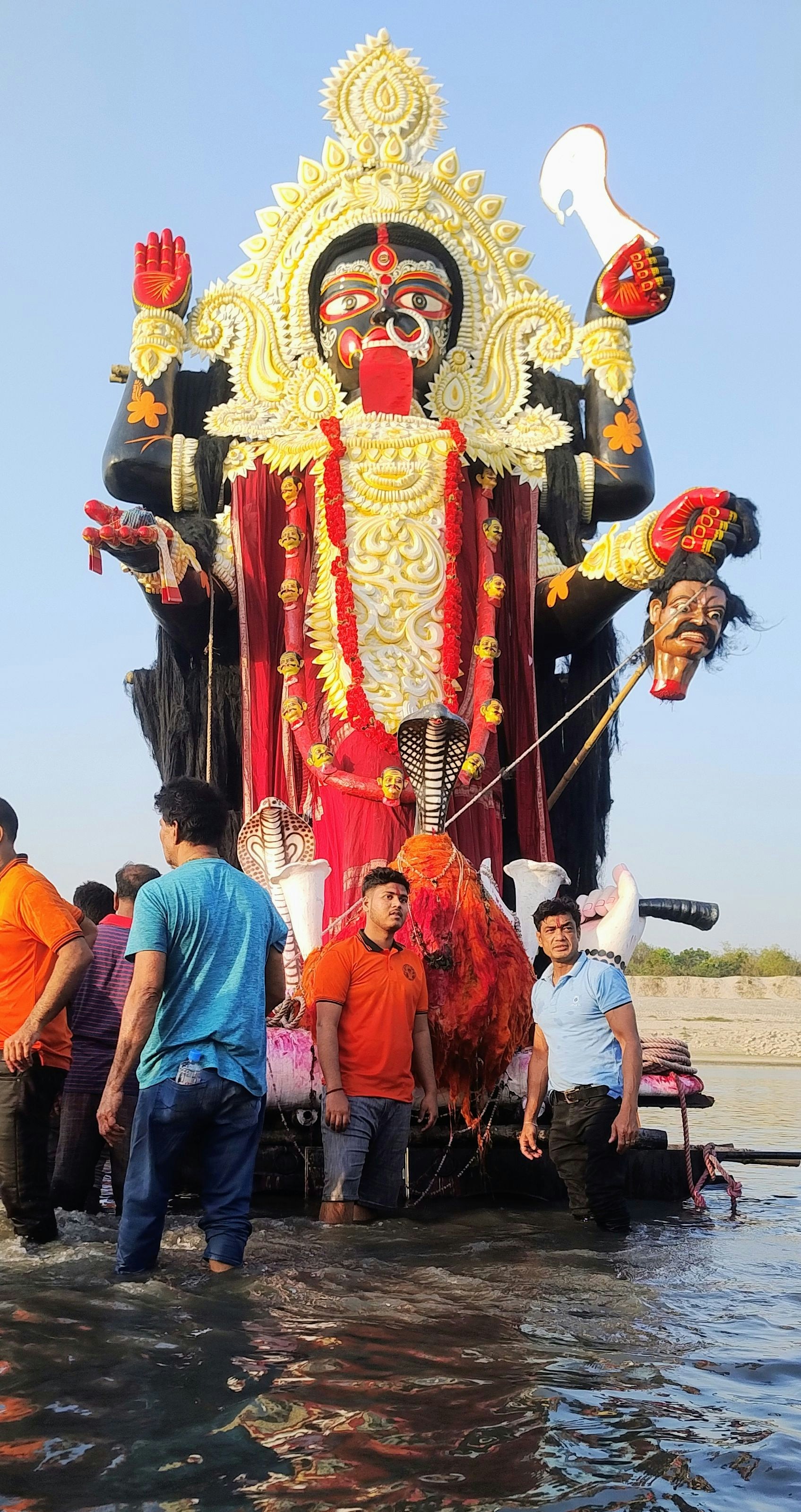 Men carry a large statue into the water. photo – Free Man Image on Unsplash