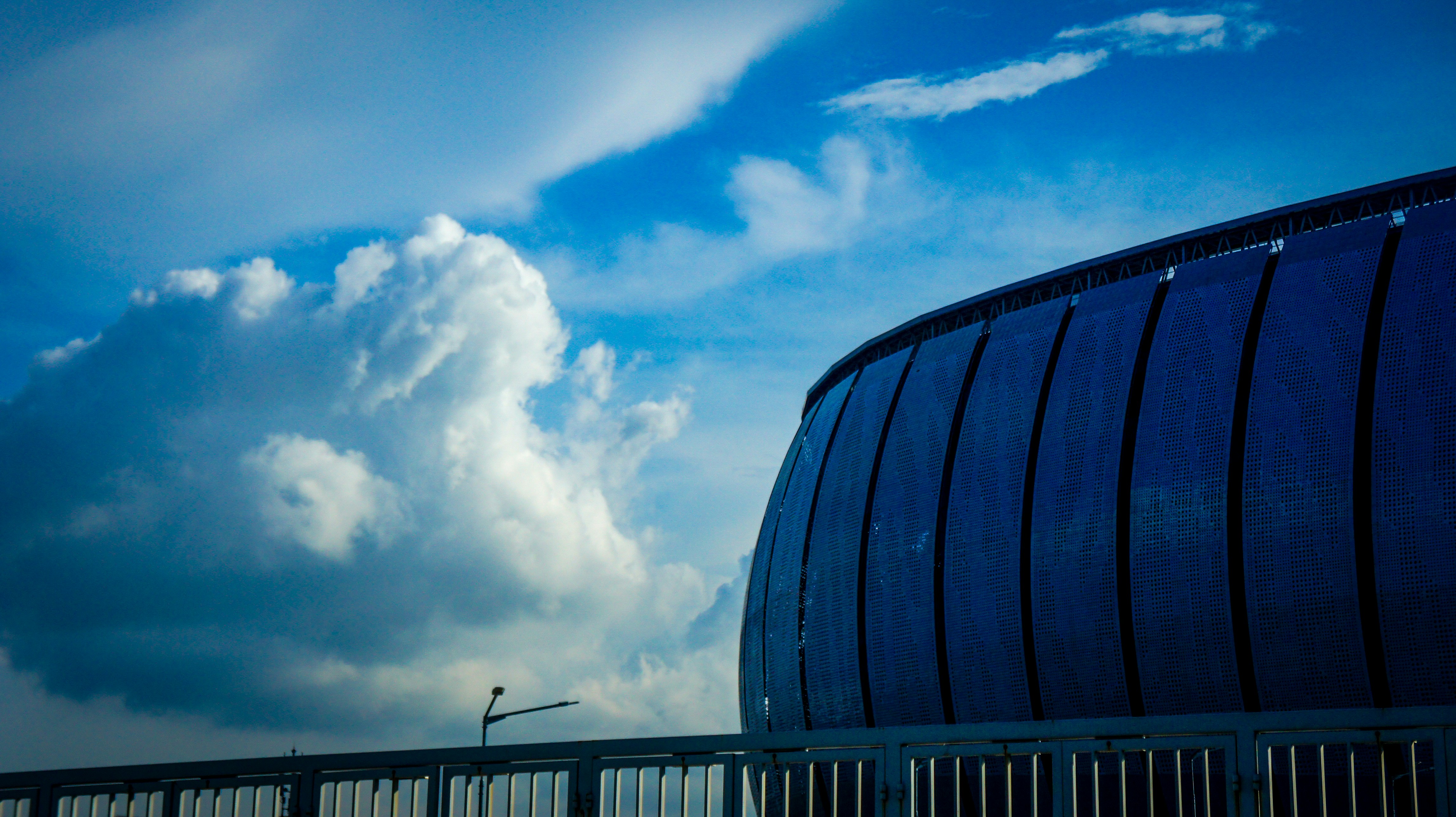 Ribbed Blue Dome Framed by Sky and Steel Rail