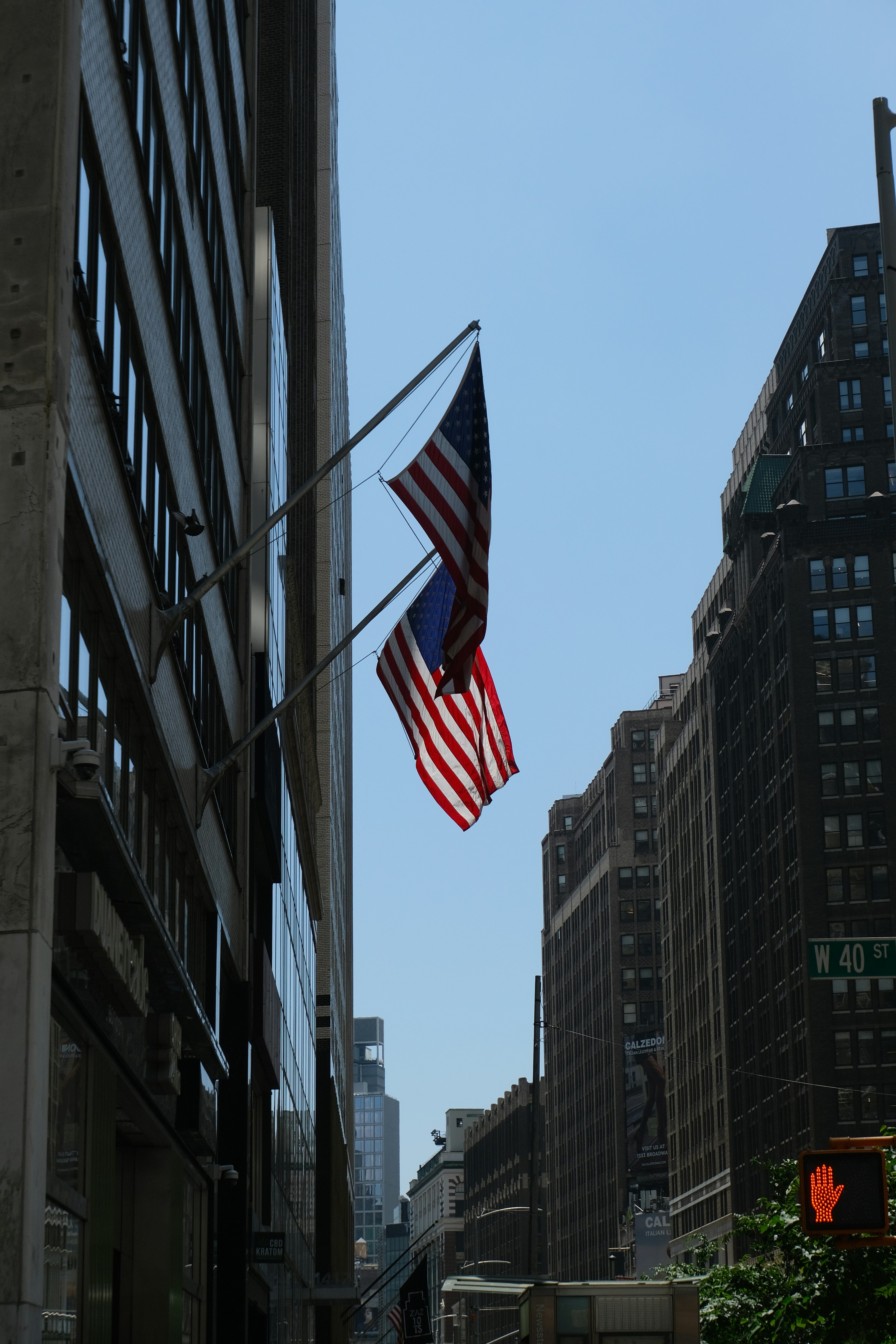Twin American Flags Framing a Narrow Midtown Street Between Glass Towers