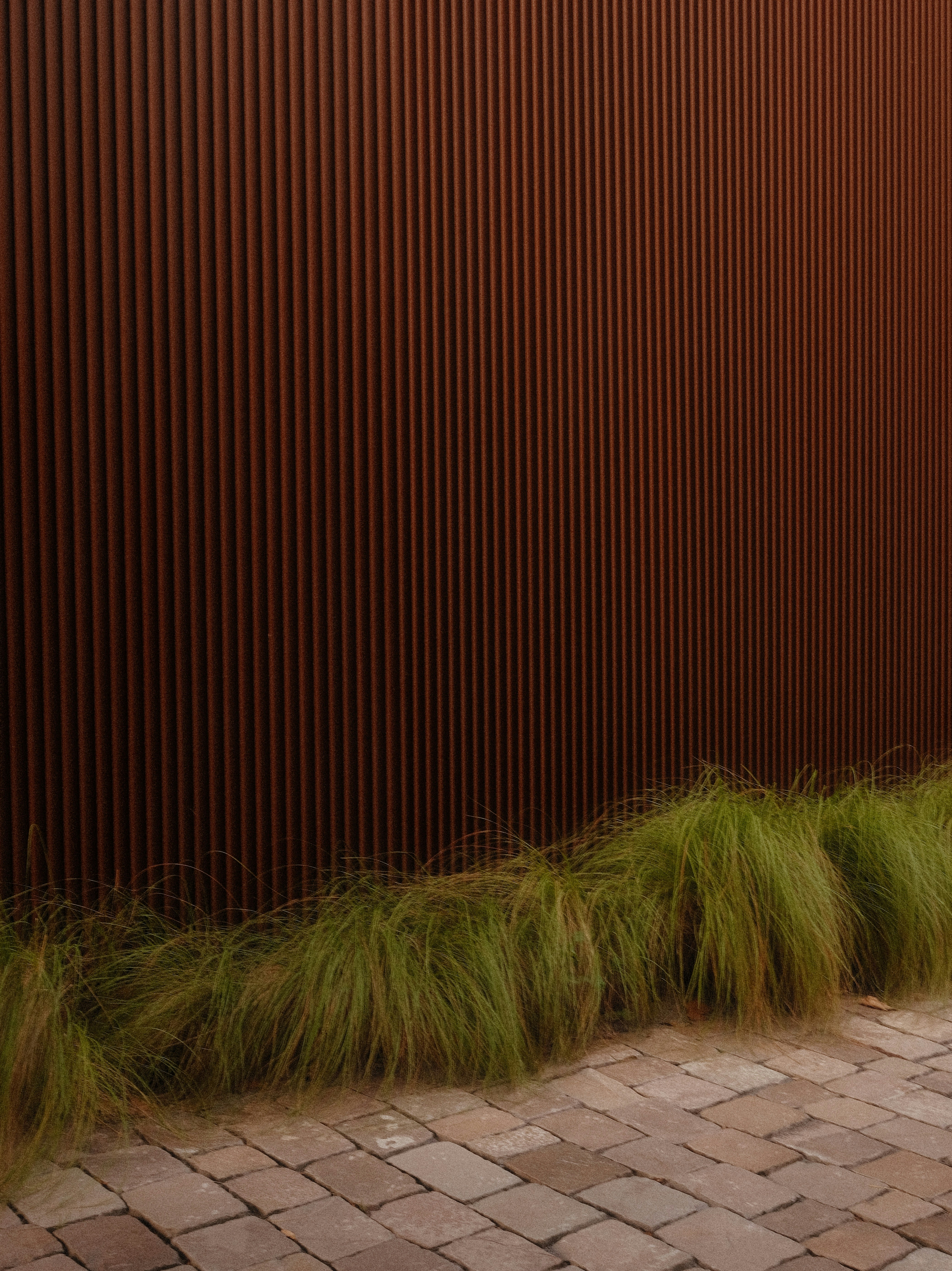 Vertical Rust: Grass and Brick Line at Ground Level