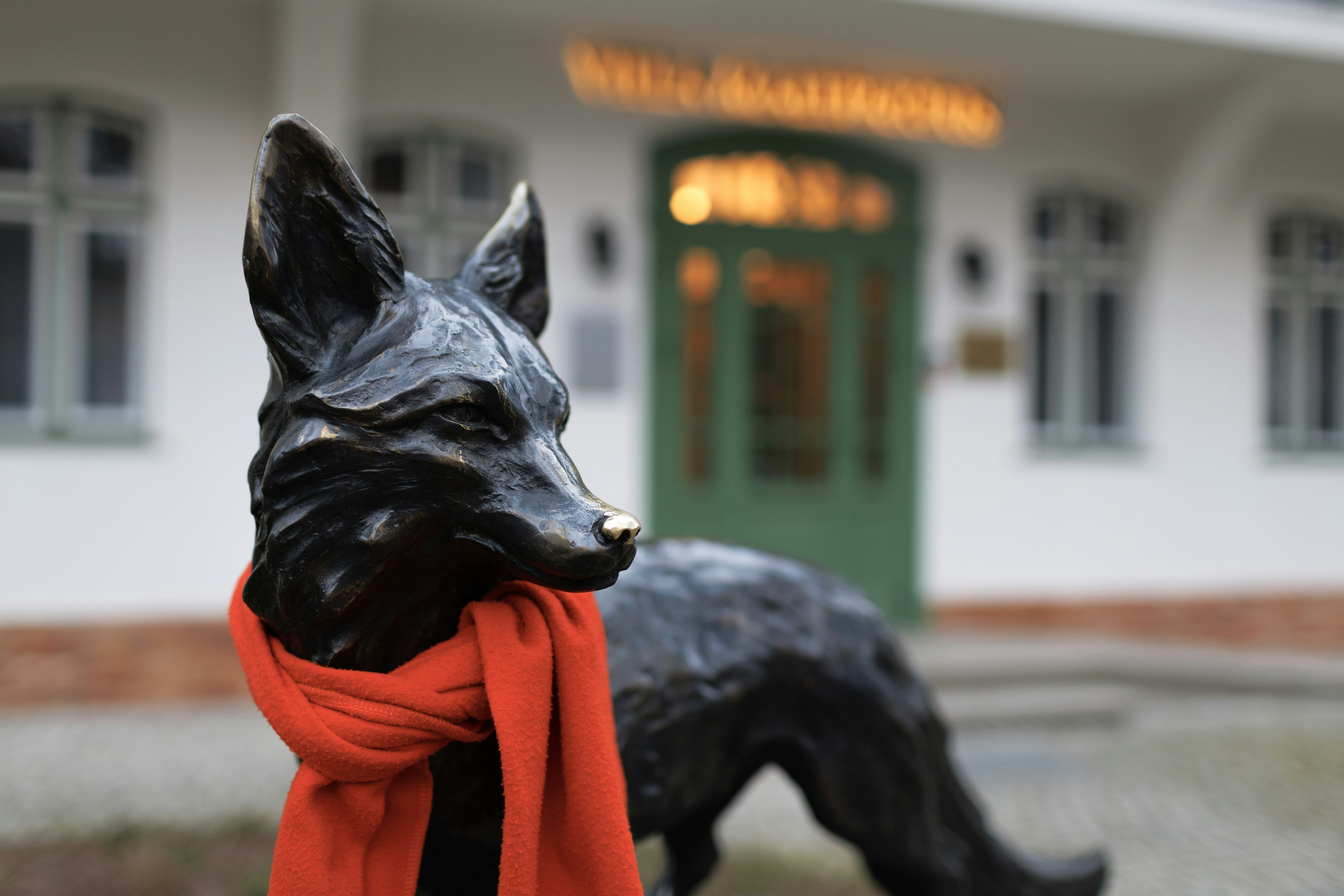 Scarlet Scarf, Dark Sentinel: A Courtyard Statue in Focus