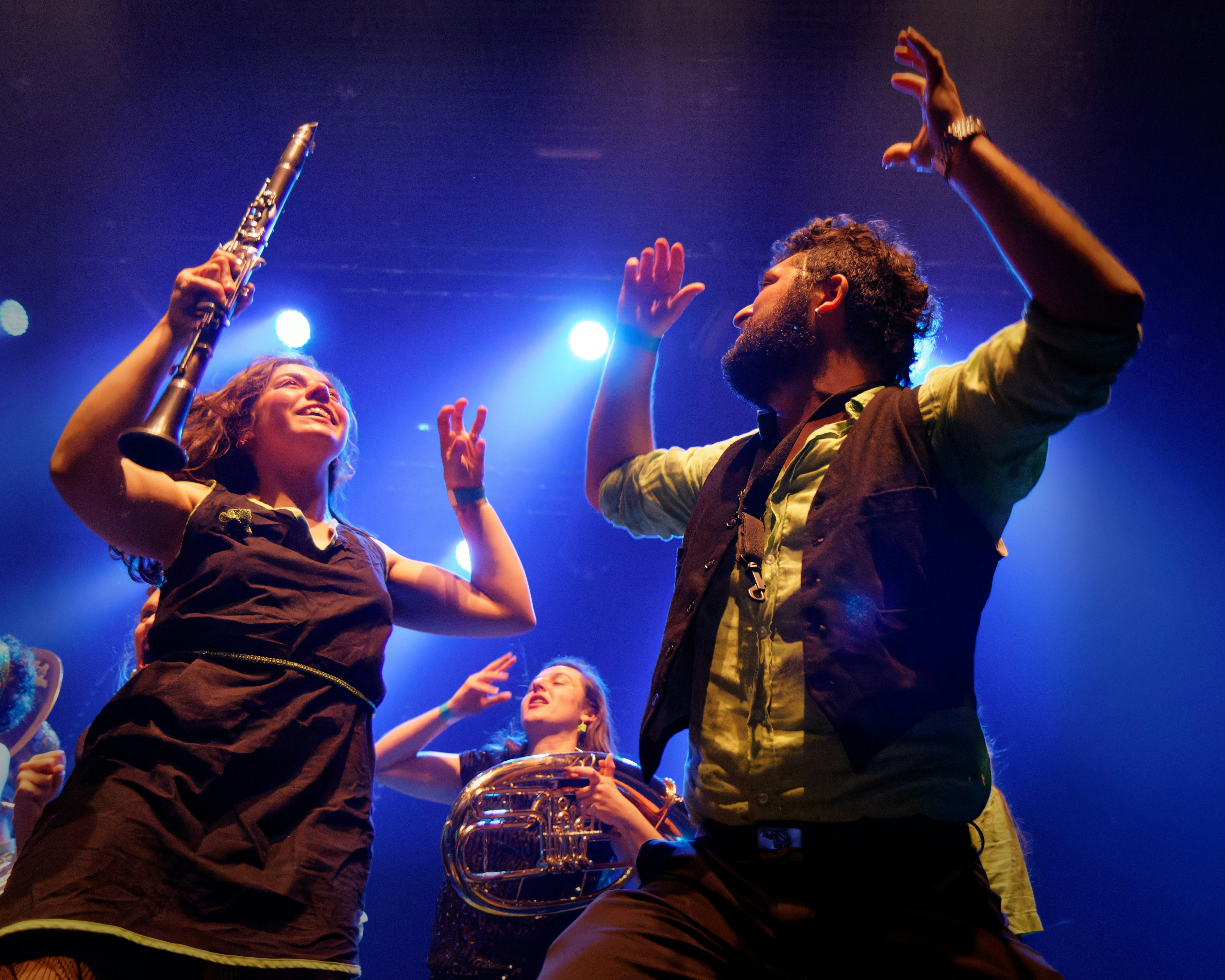 Musicians passionately performing on stage with vibrant blue lighting.