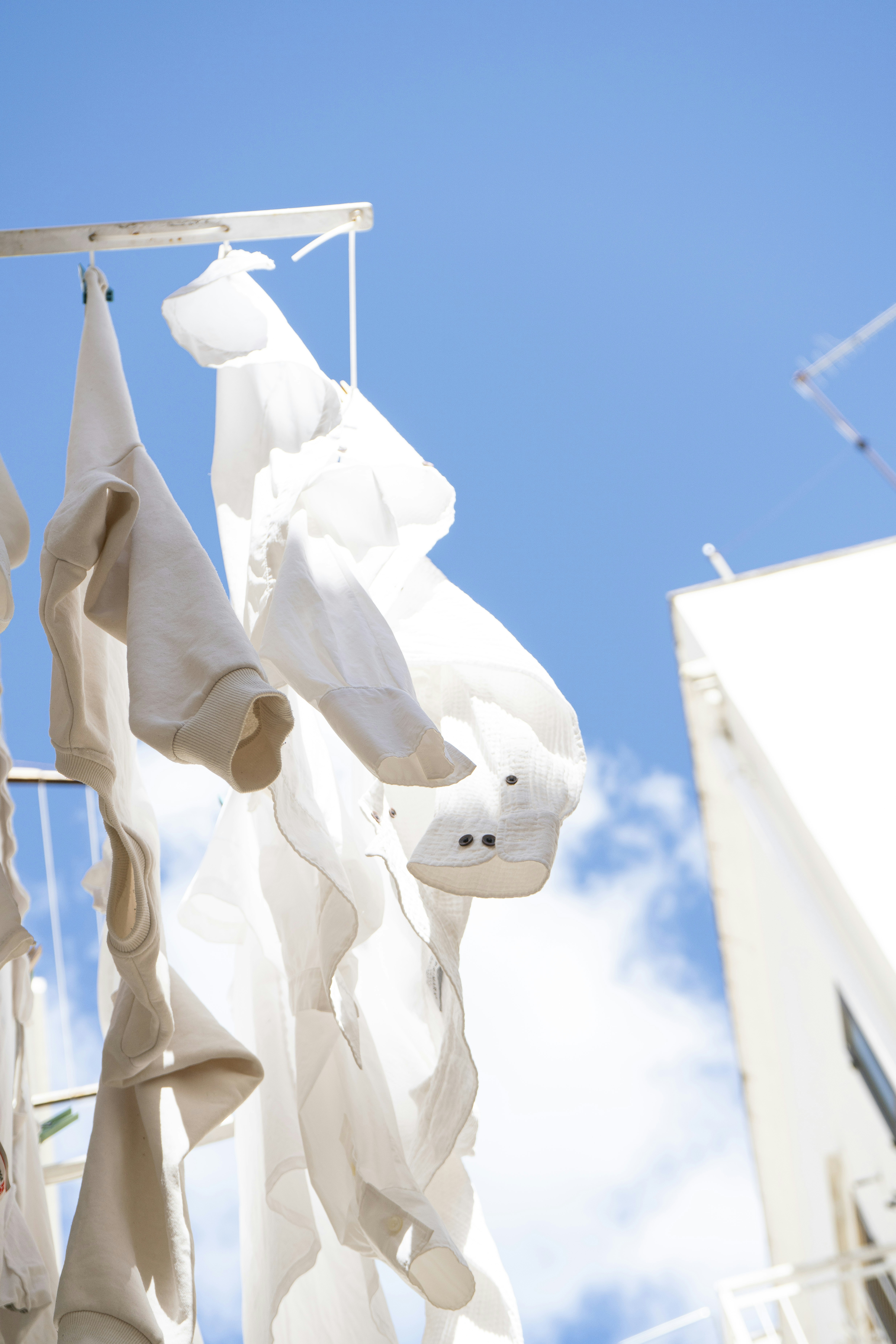 Sunlit White Fabrics on a Balcony Clothesline Against a Cobalt Sky