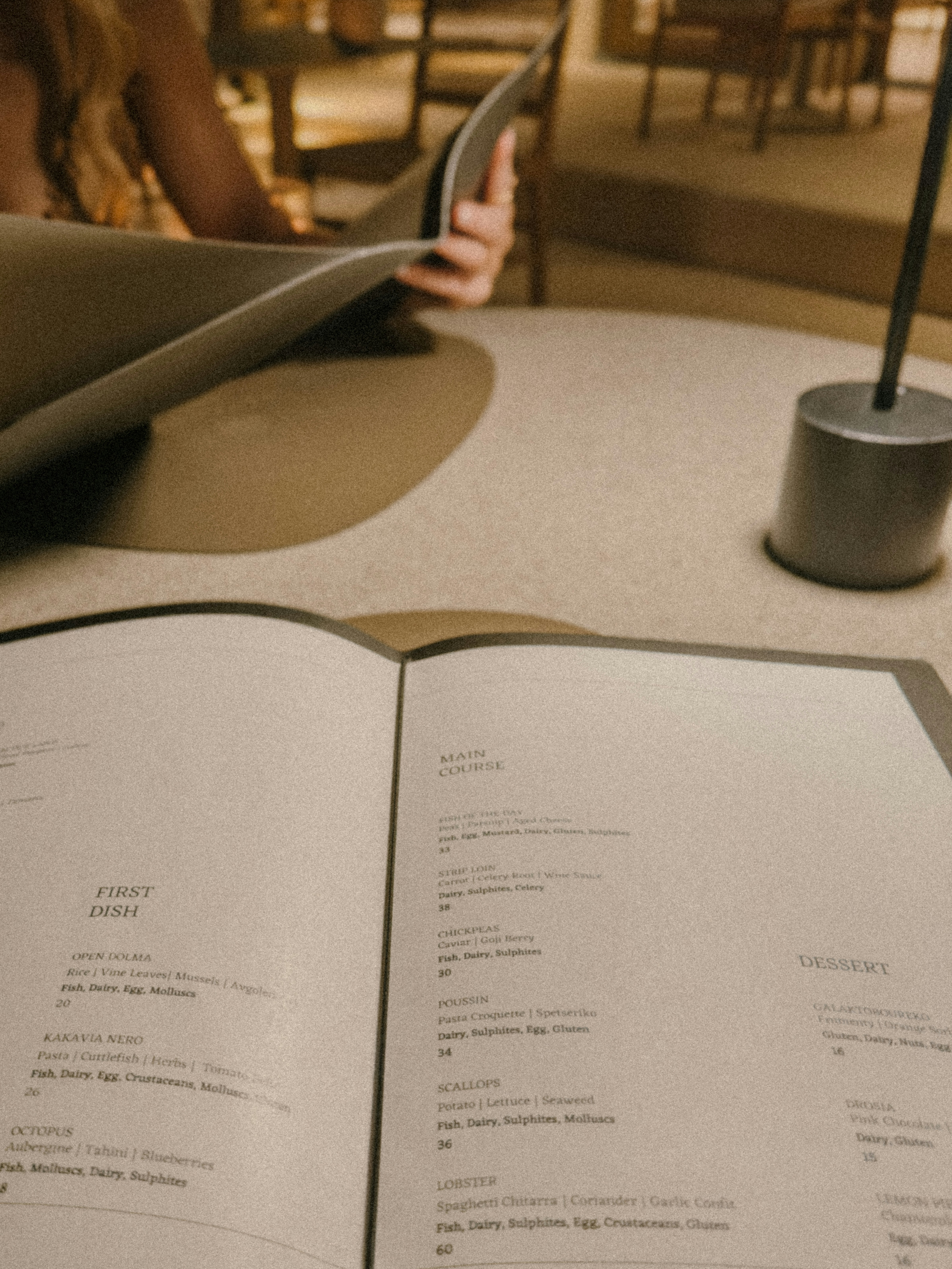 Open menu on a restaurant table with warm, ambient lighting.