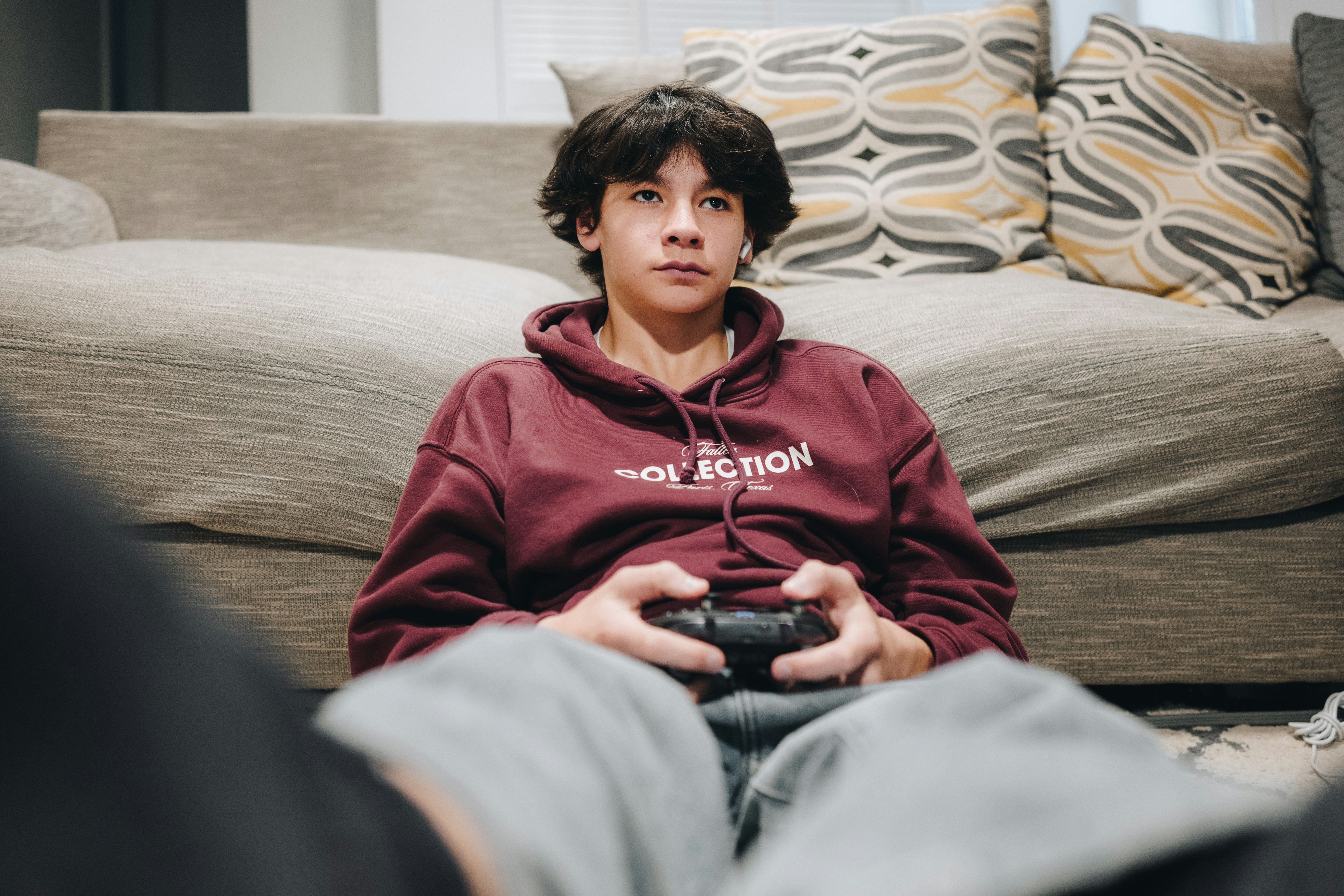Teen gaming at home in his living room. | A young boy is playing a video game.