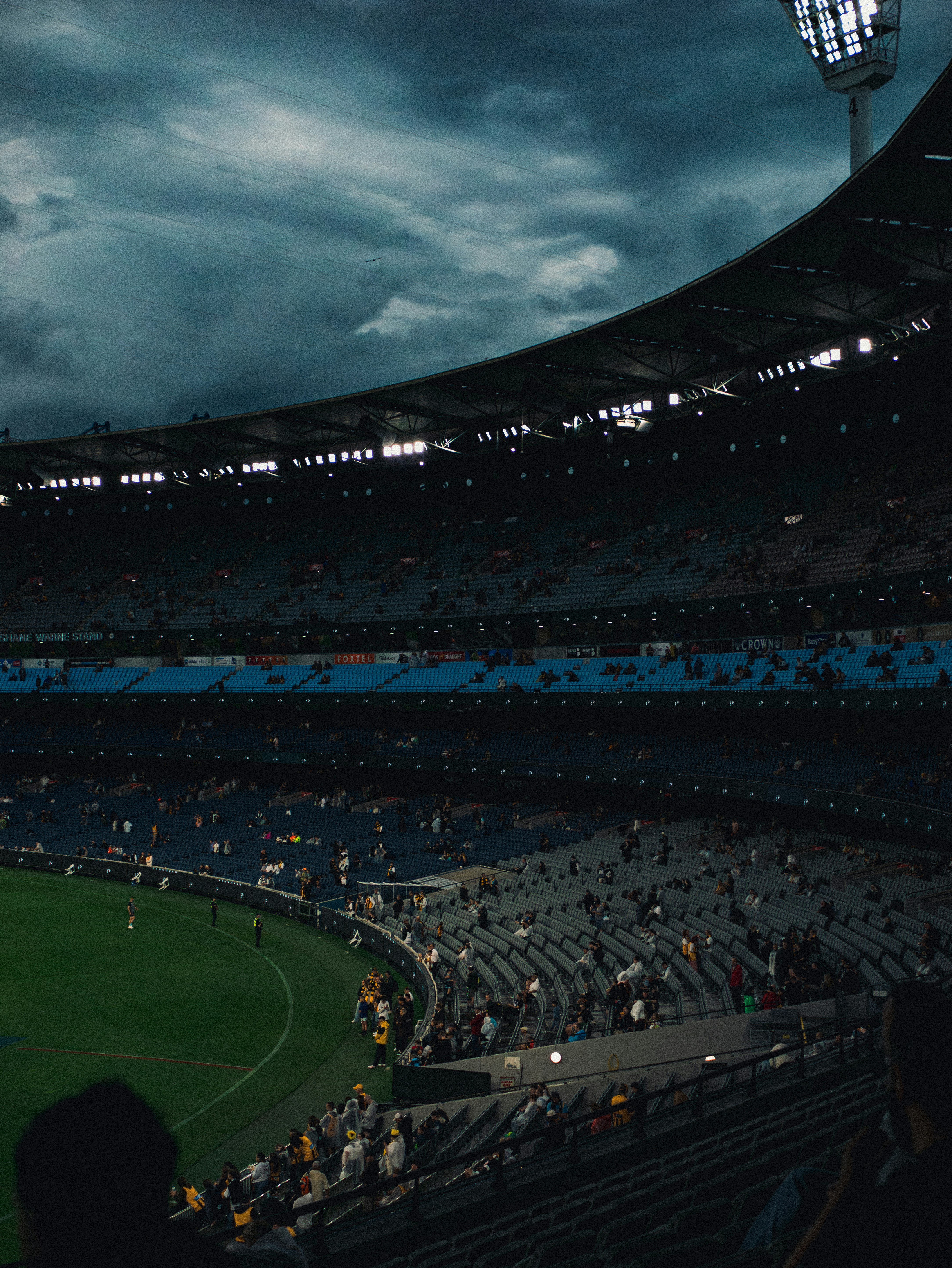 An evening football game played under stormy skies.