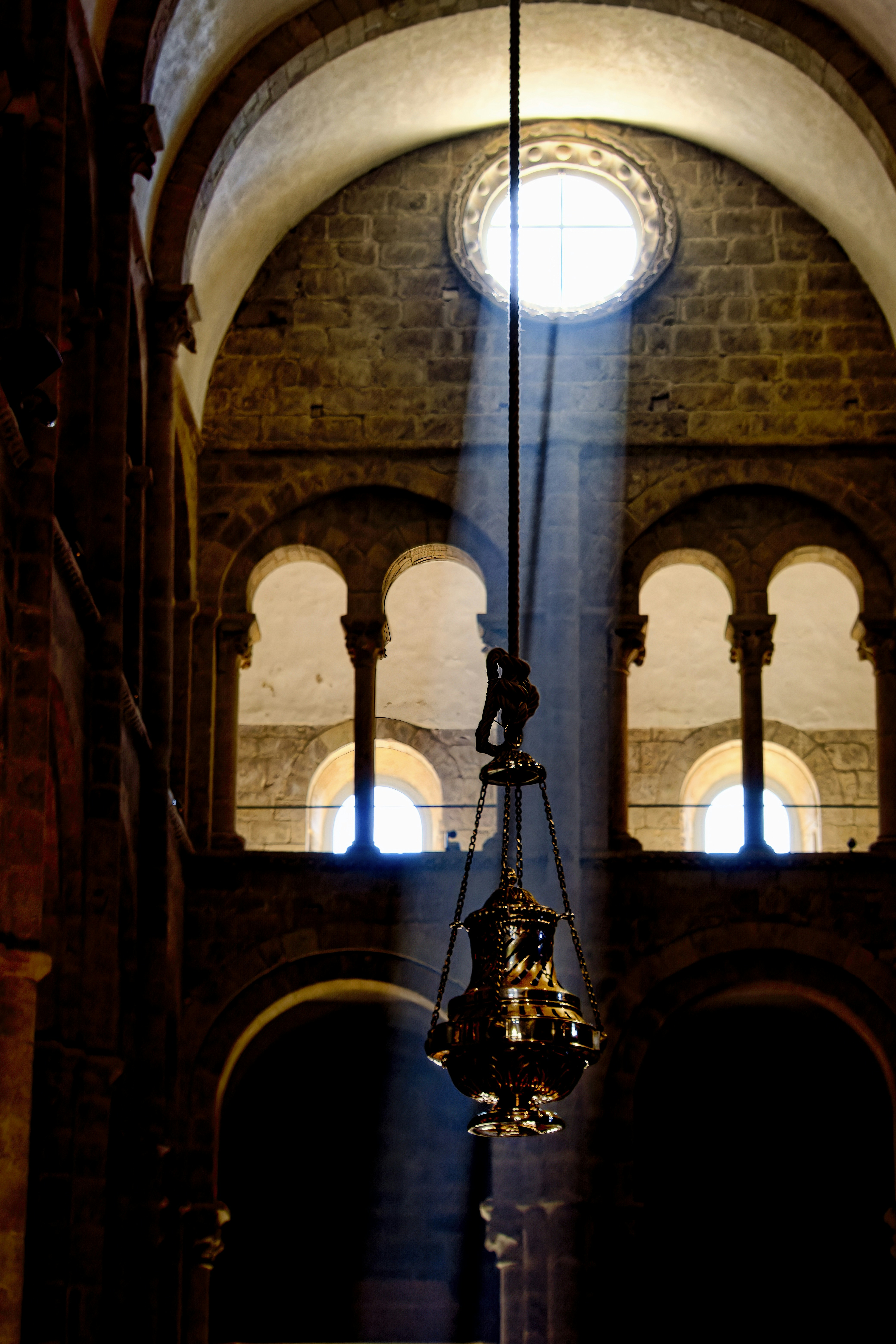 Beaming Lantern Between Archways in a Sunlit Cloister