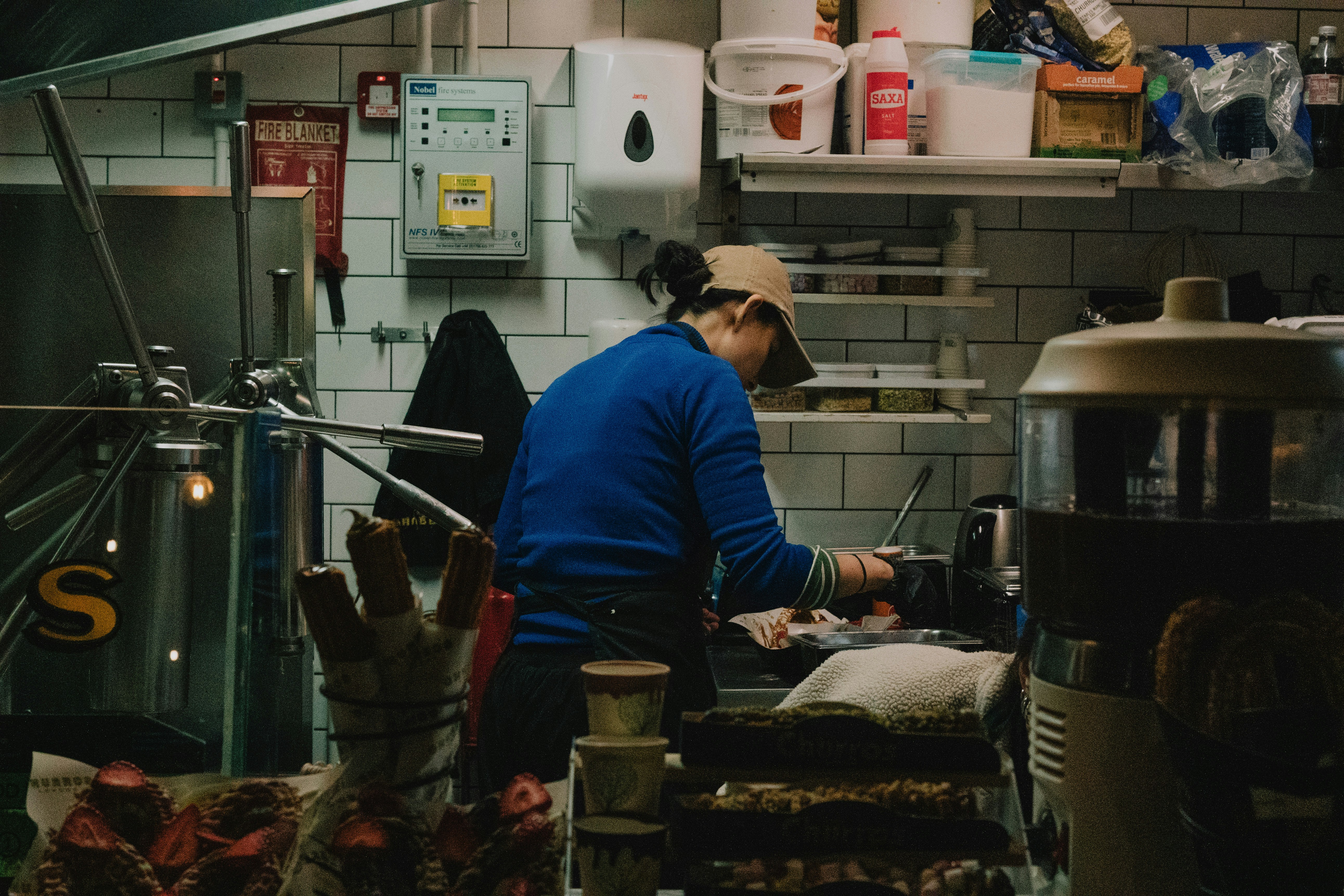 A person cooks in a busy restaurant kitchen. photo – Free Food Image on ...