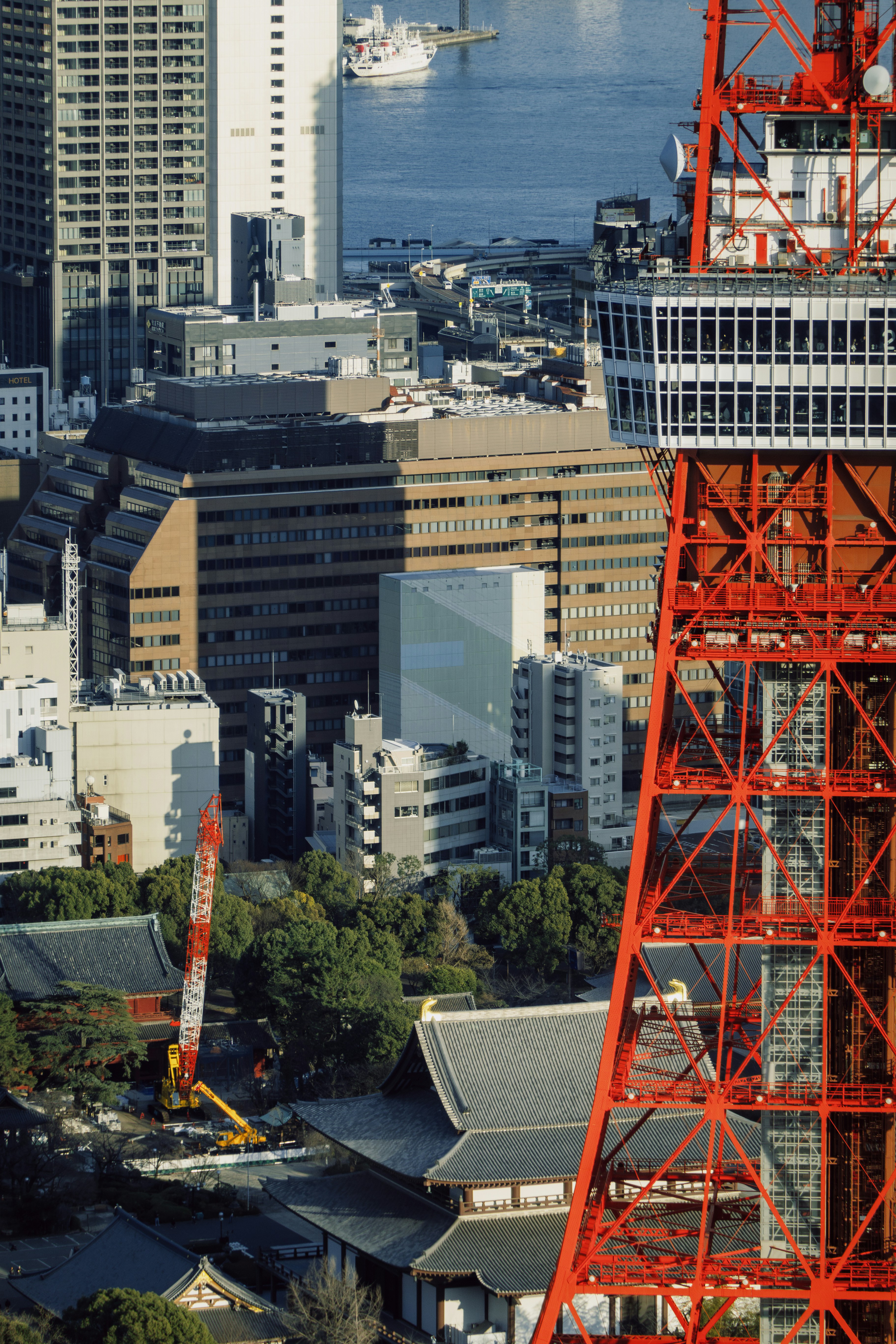 Red Lattice Beacon Over a Glassy Cityscape and Harbor