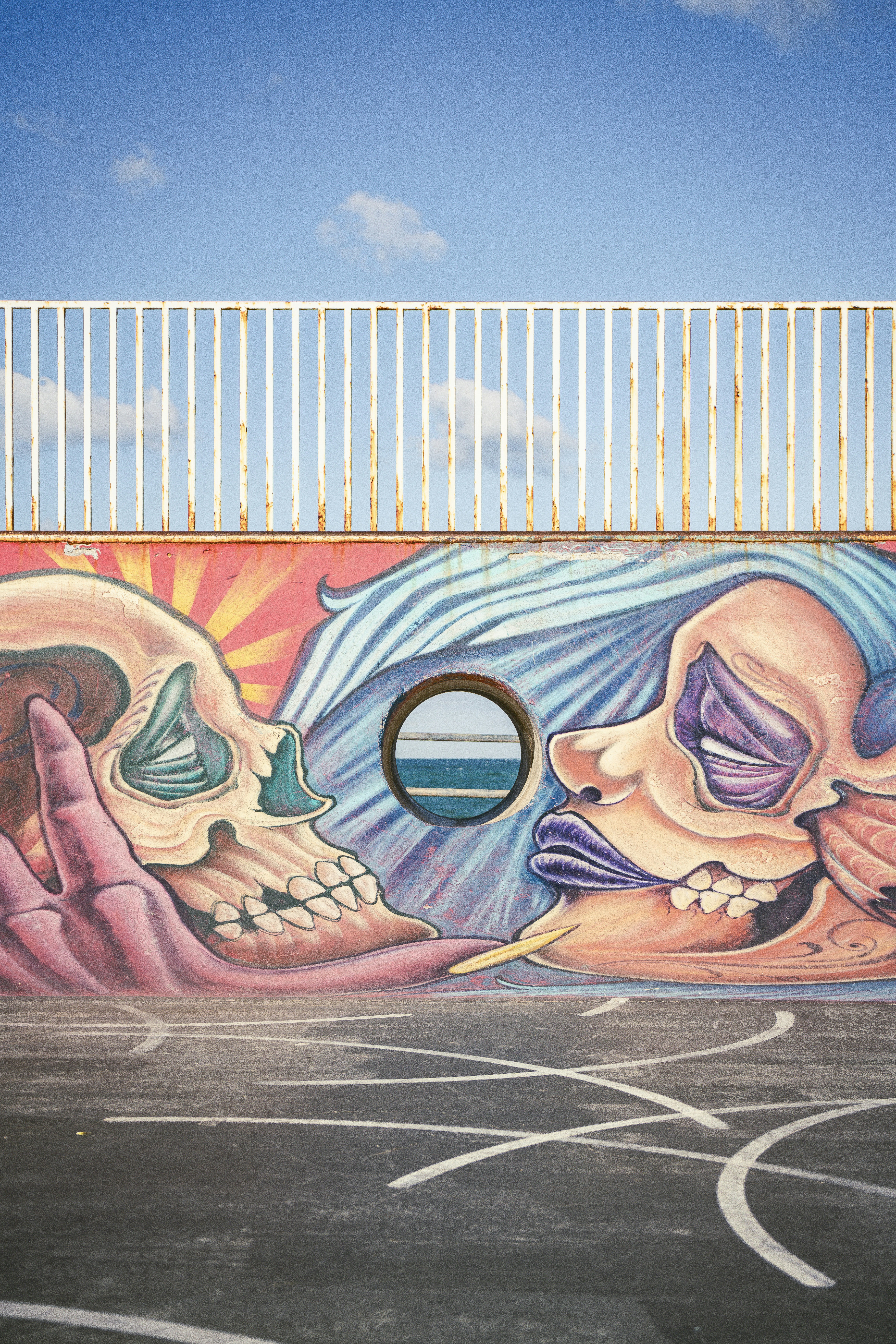 Circular Portal Between Graffiti Skulls Reveals a Sea View
