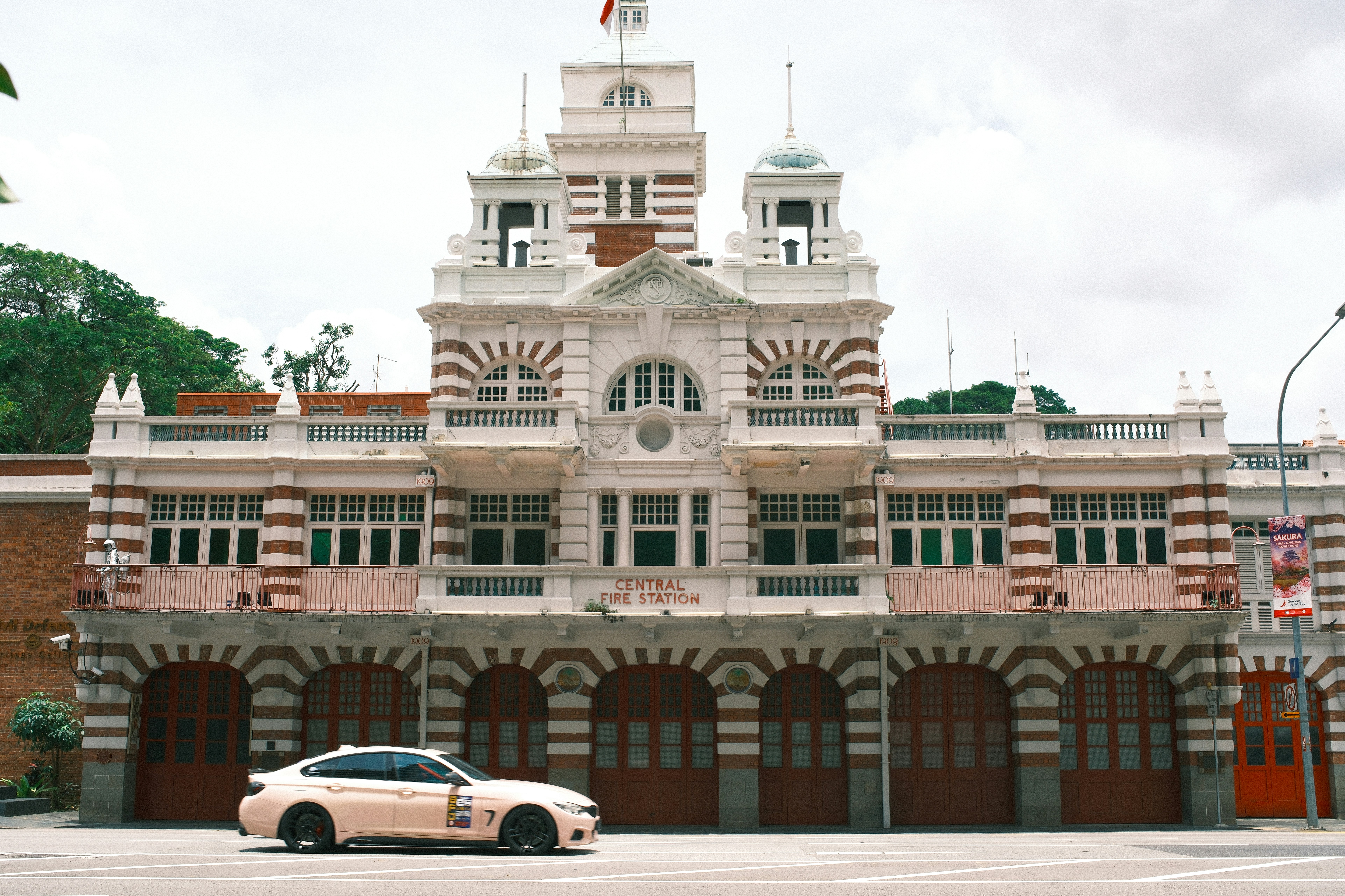 Pastel Taxi Before a Striped City Station Facade