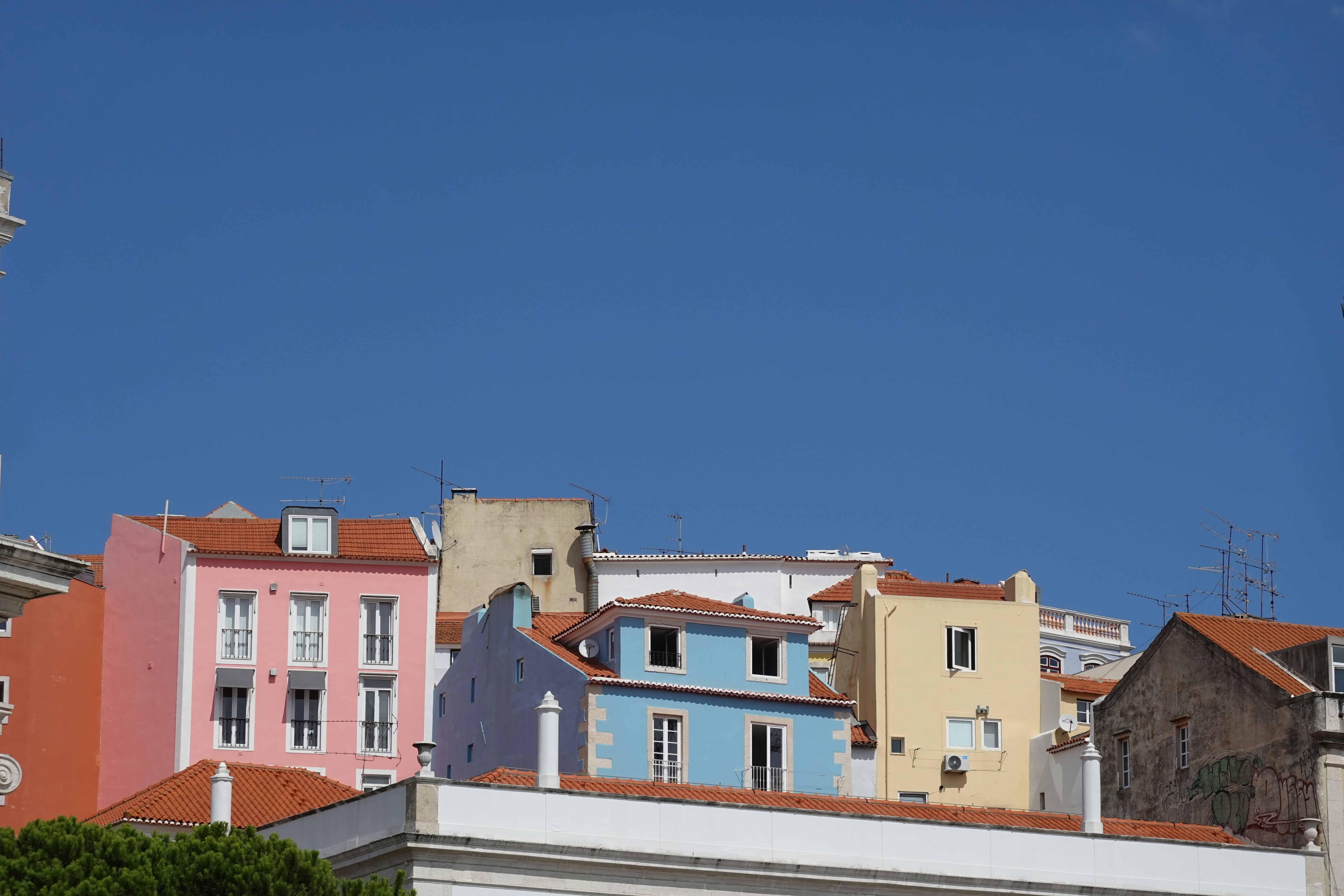 Colorful buildings in Lisbon with a clear blue sky backdrop.