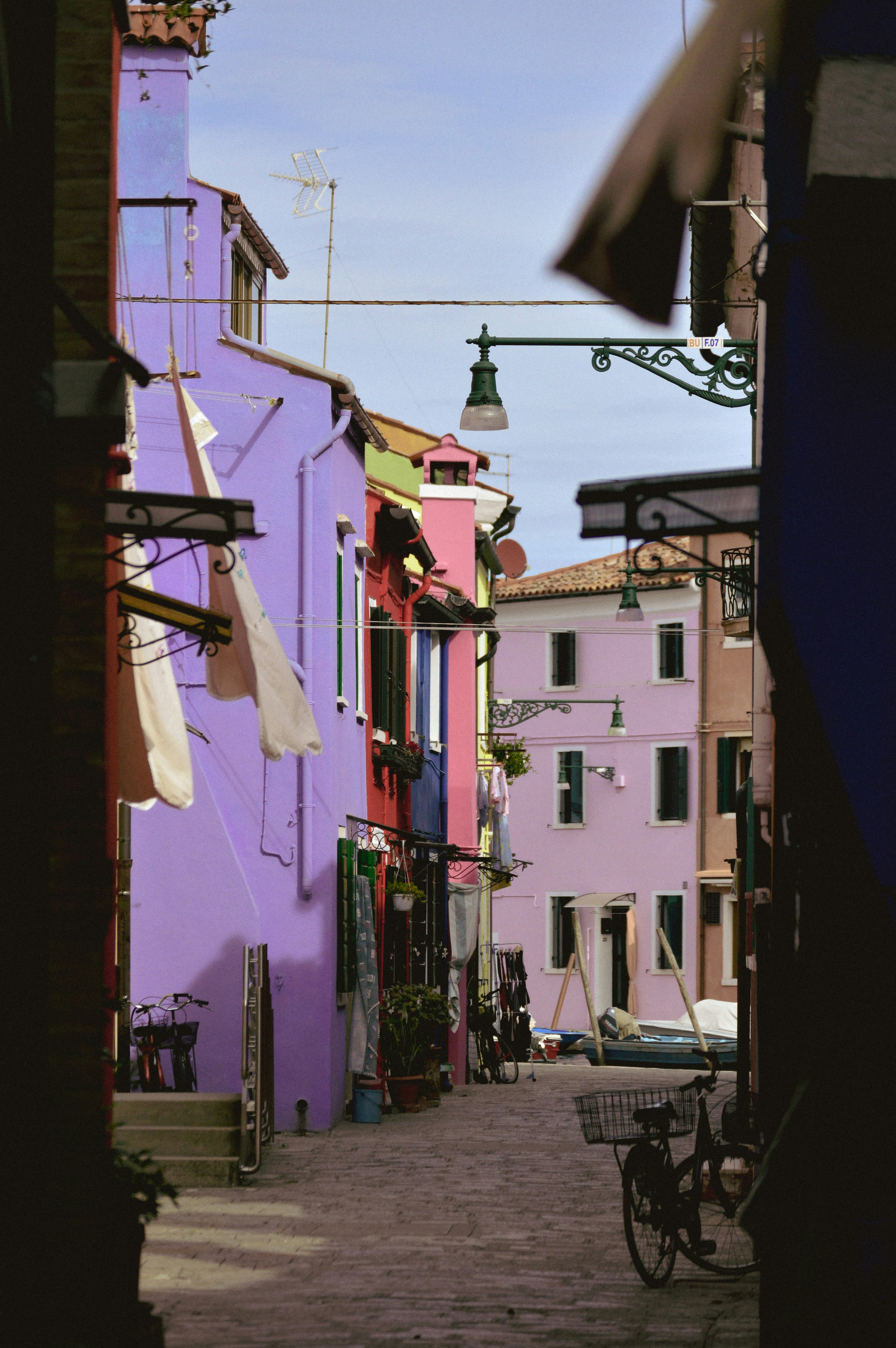 Lavender Lane: Sunlit Alley of Candy-Colored Facades with a Quiet Bicycle