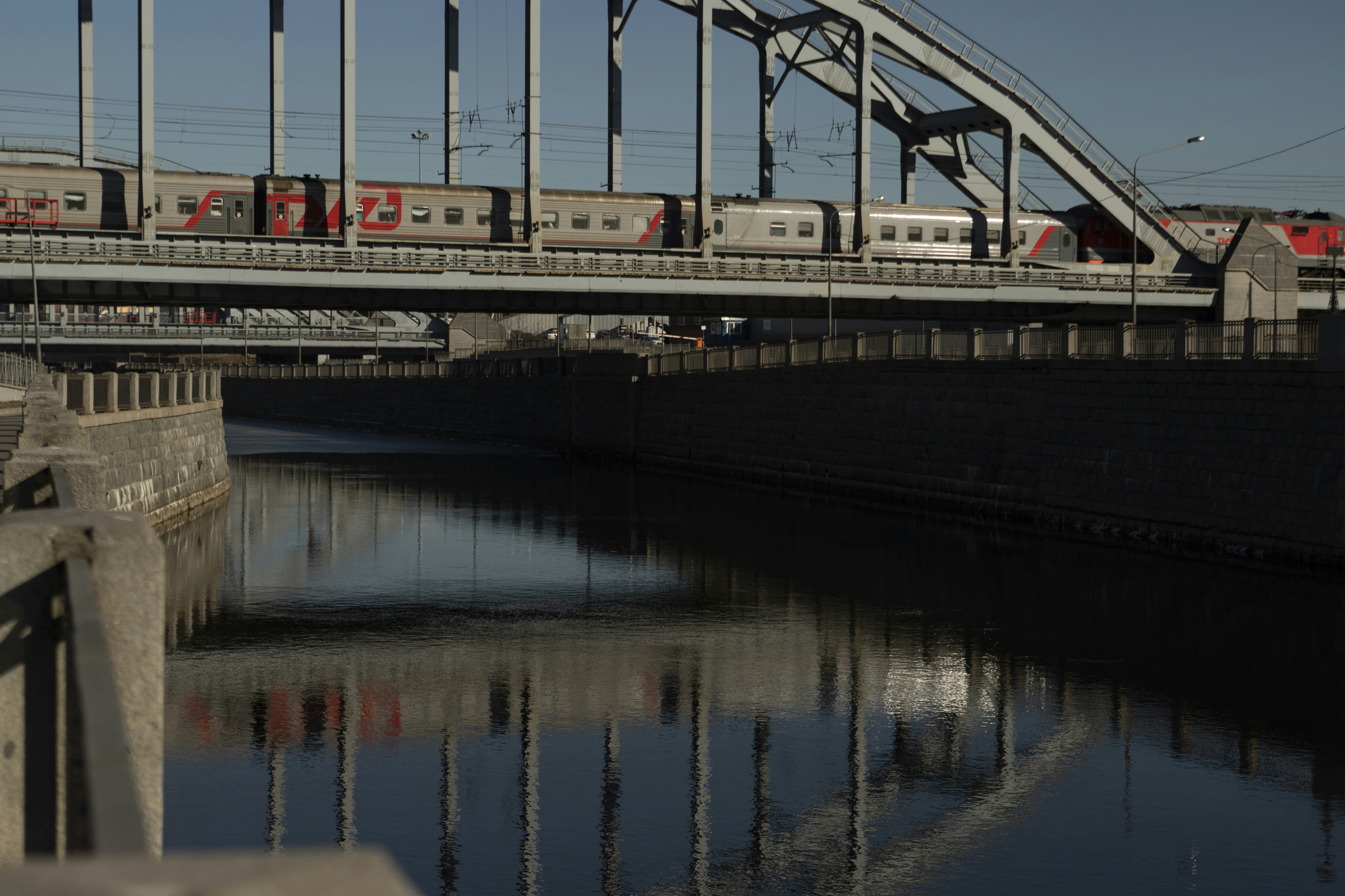 A train travels across a bridge over water. photo – Free Train Image on ...