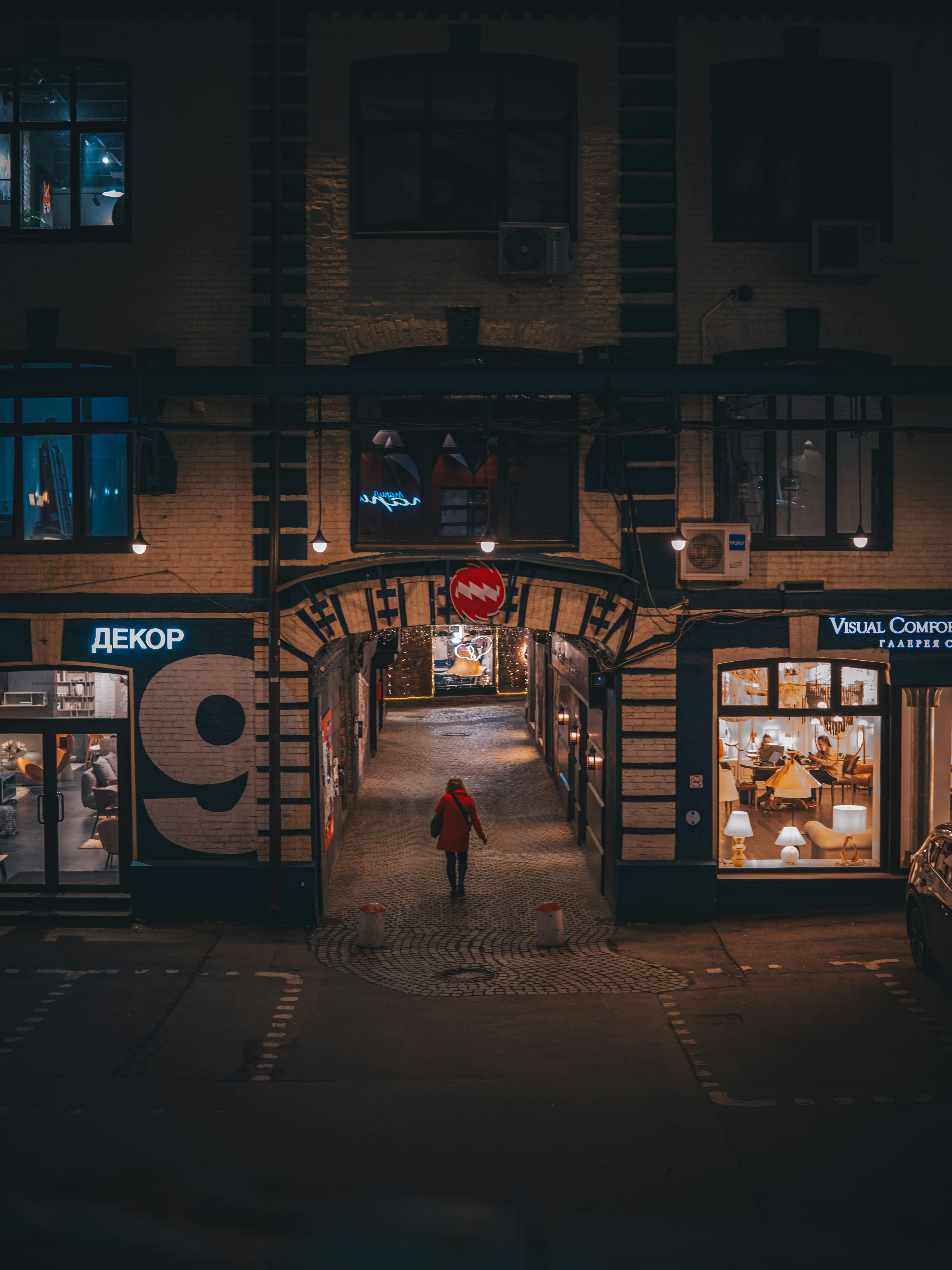 Red Coat at the Archway of Light: A Quiet Night Walk Through the City Arcade