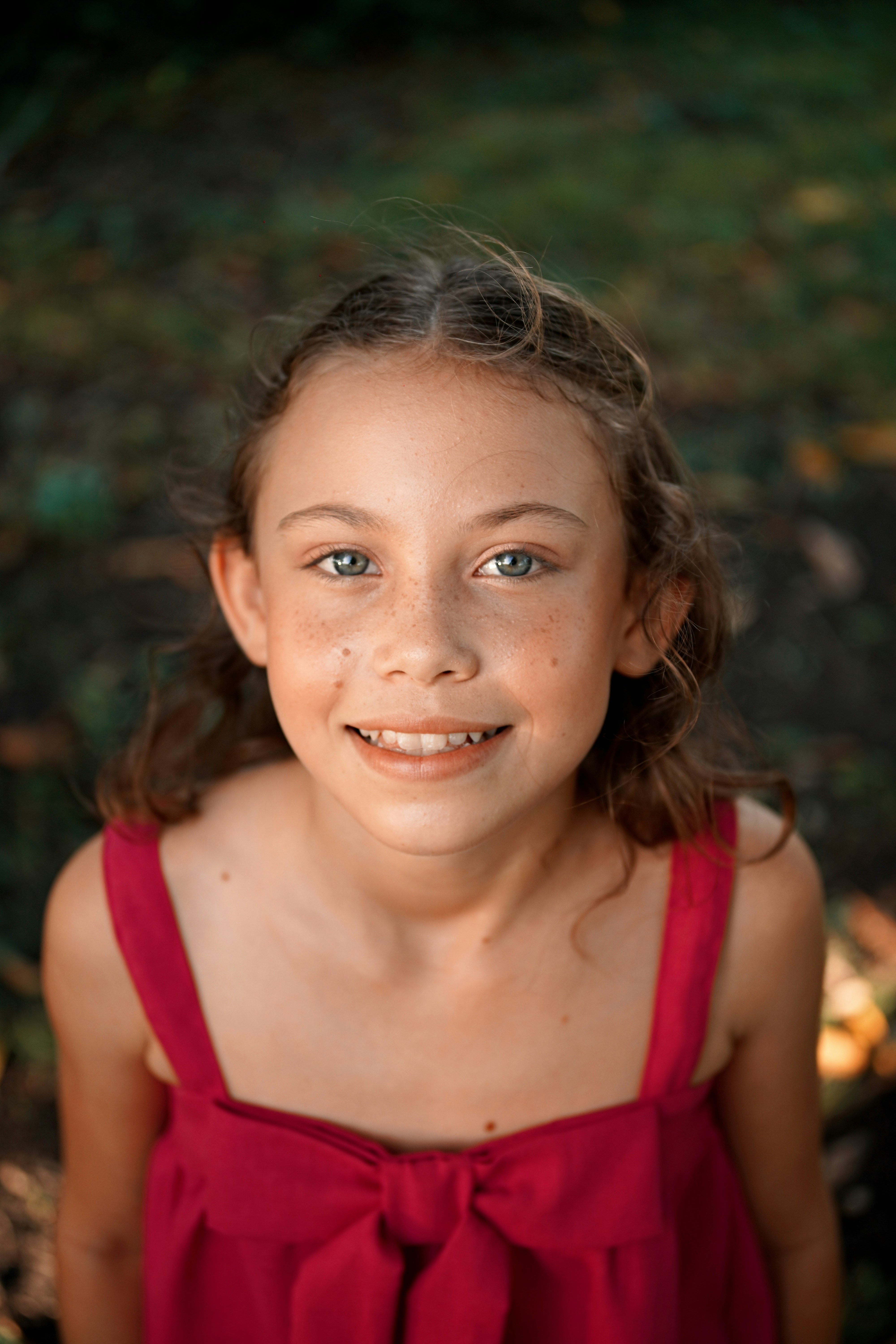 A smiling girl looks up at the camera. photo – Free Portrait Image on ...