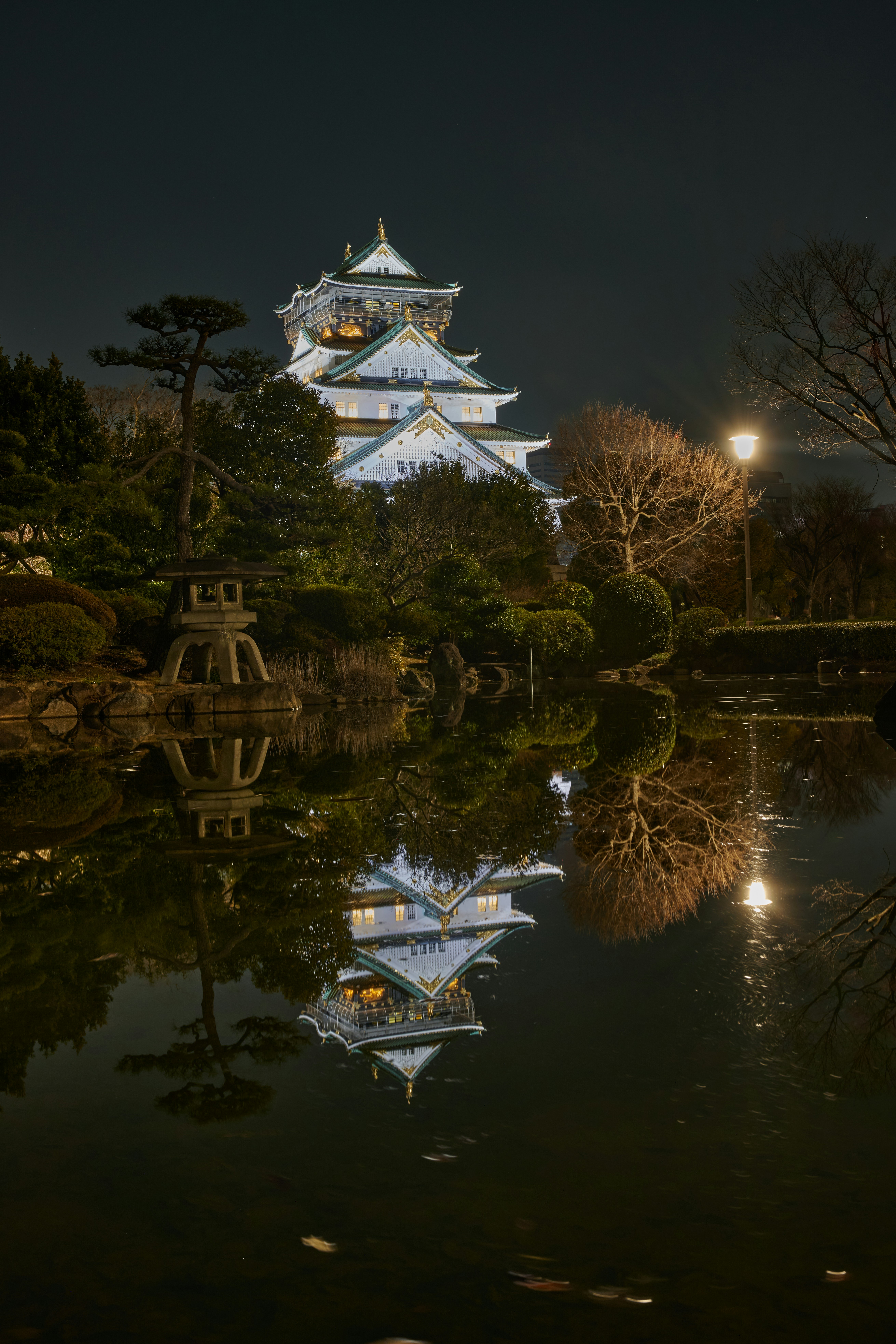 Osaka castle is beautifully reflected in the water at night.