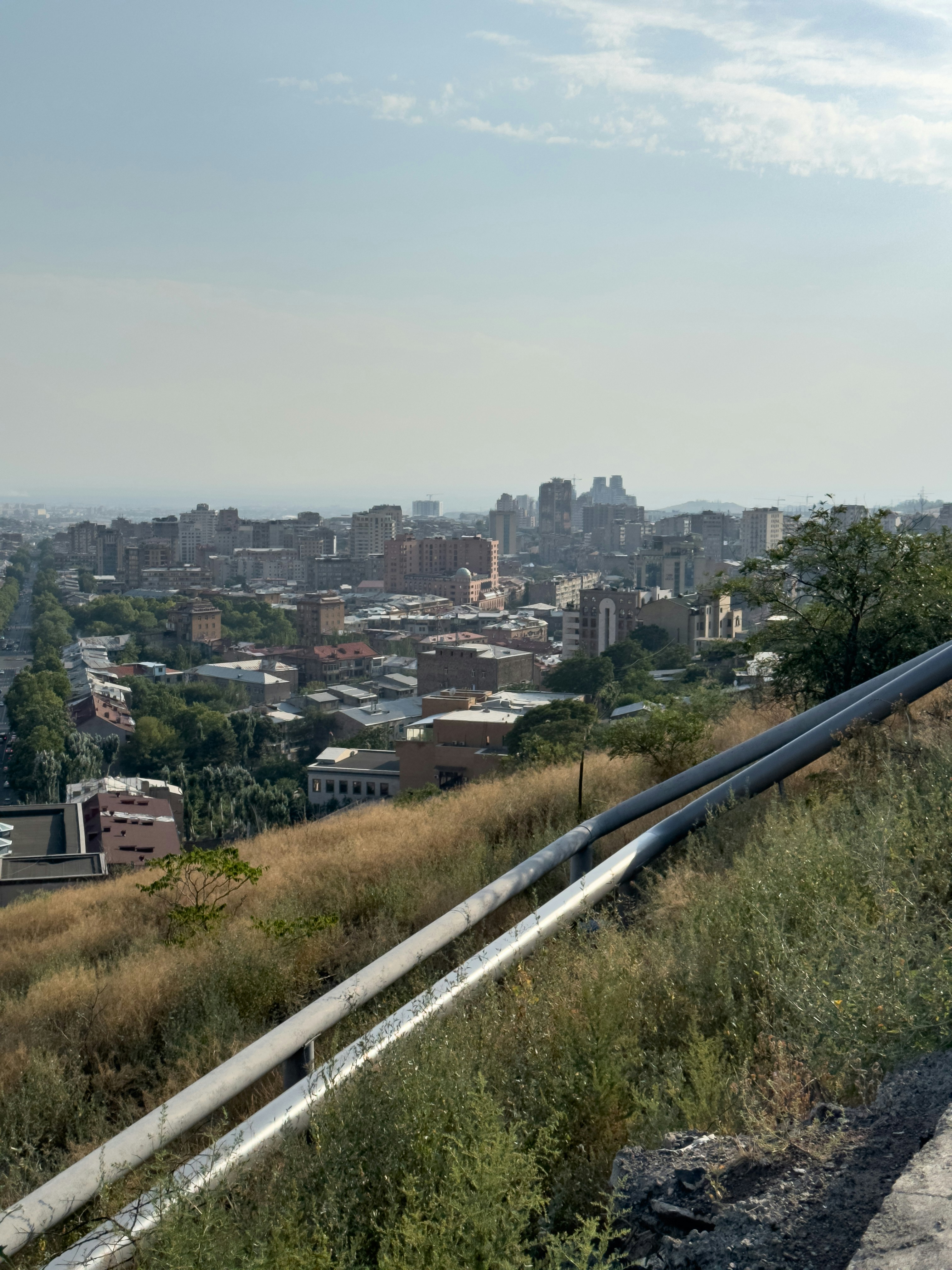Horizon Over the Hills: A Cityscape Framed by a Diagonal Guardrail