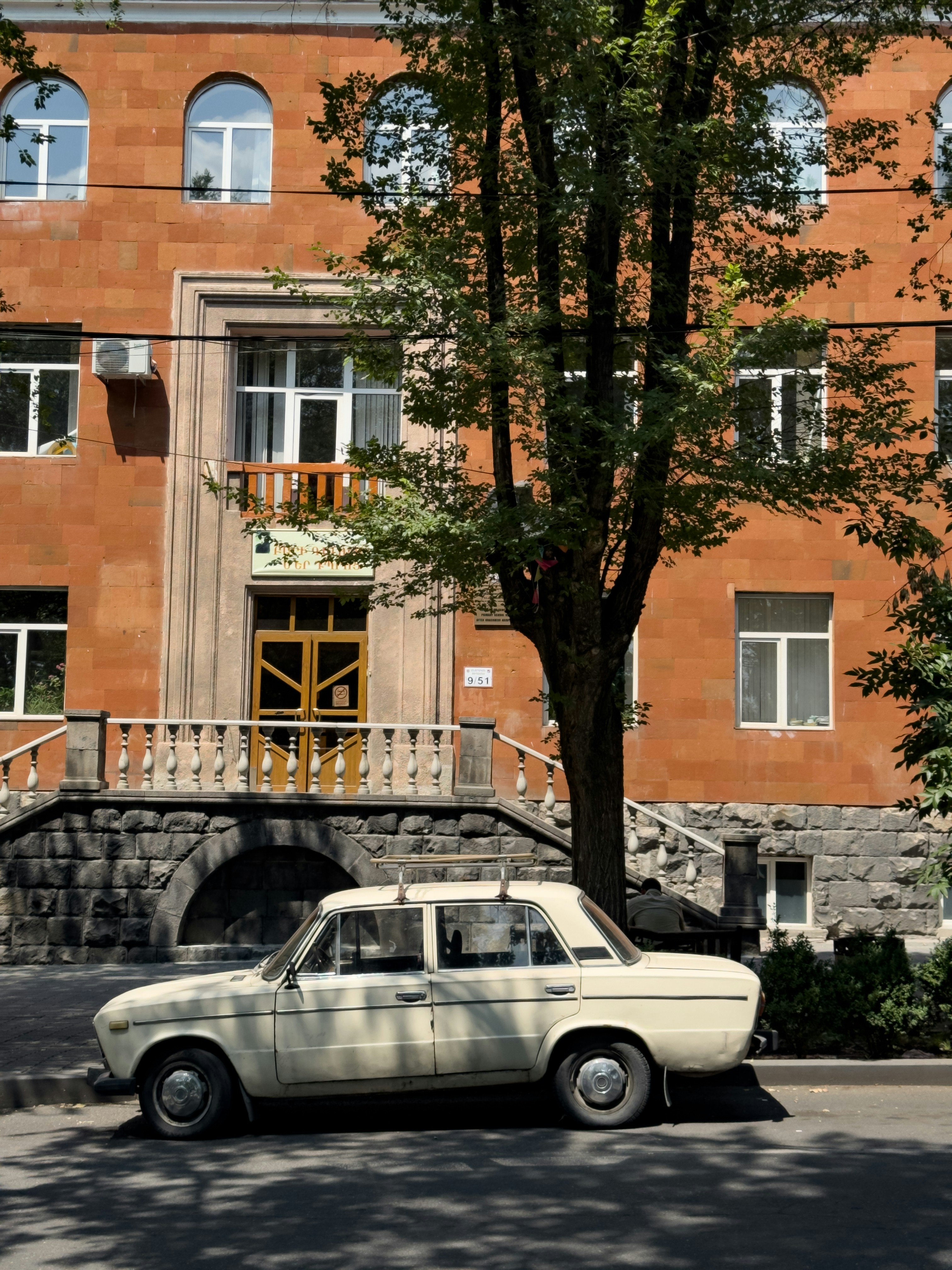An old car parked in front of a building. photo – Free Car Image on ...