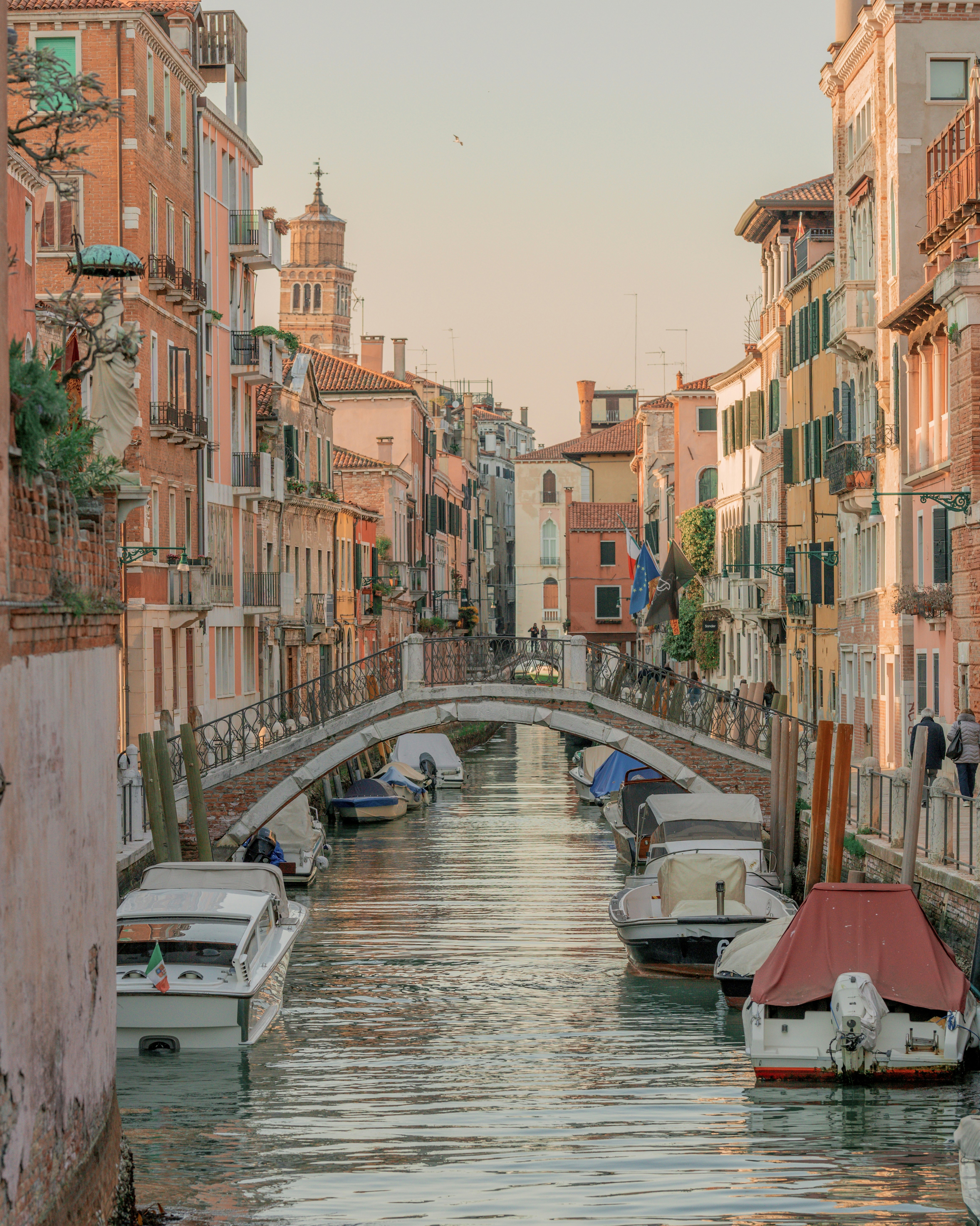 Serene canal flanked by historic buildings under a soft morning light.