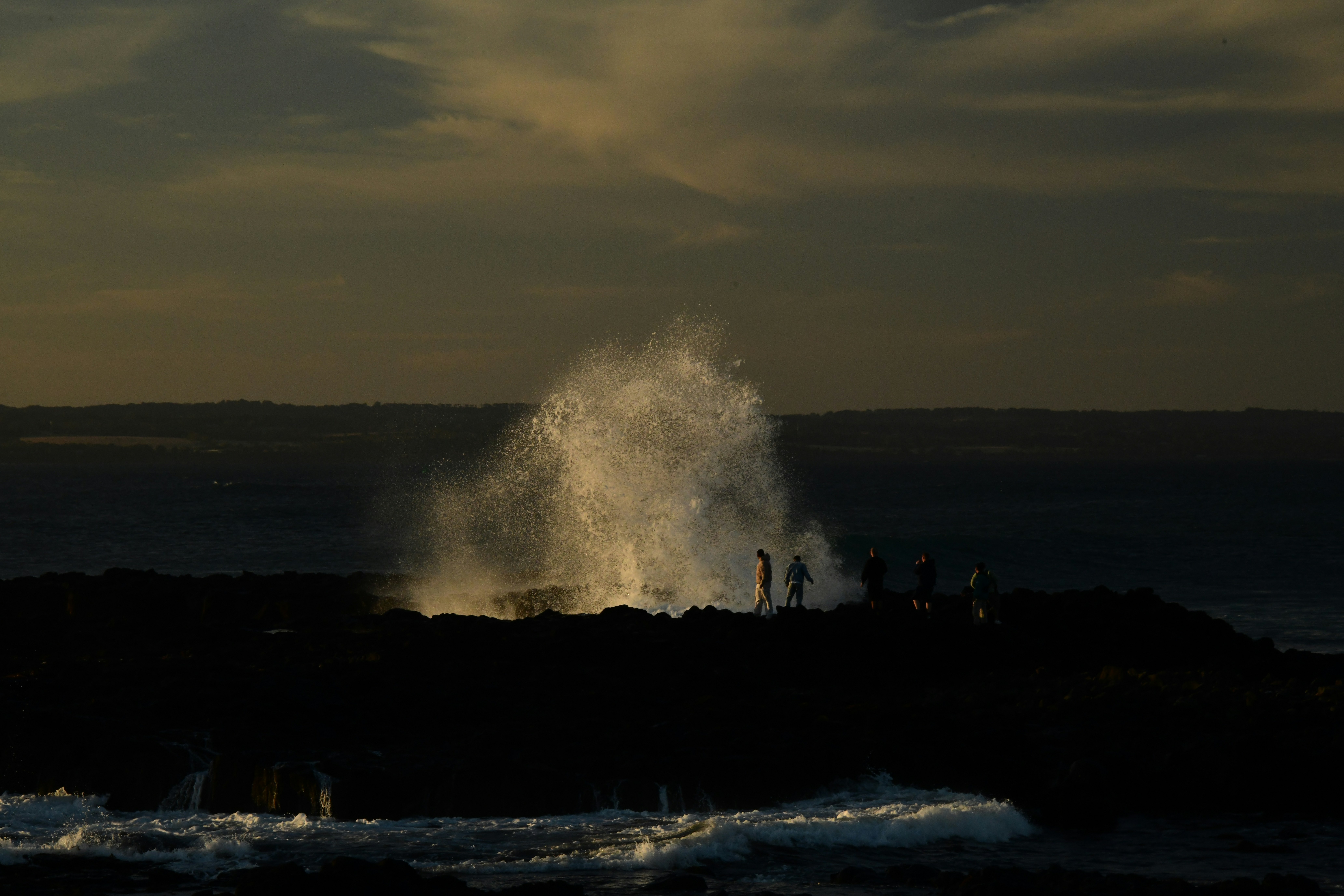 Dusk Surge Over Silhouetted Rocks