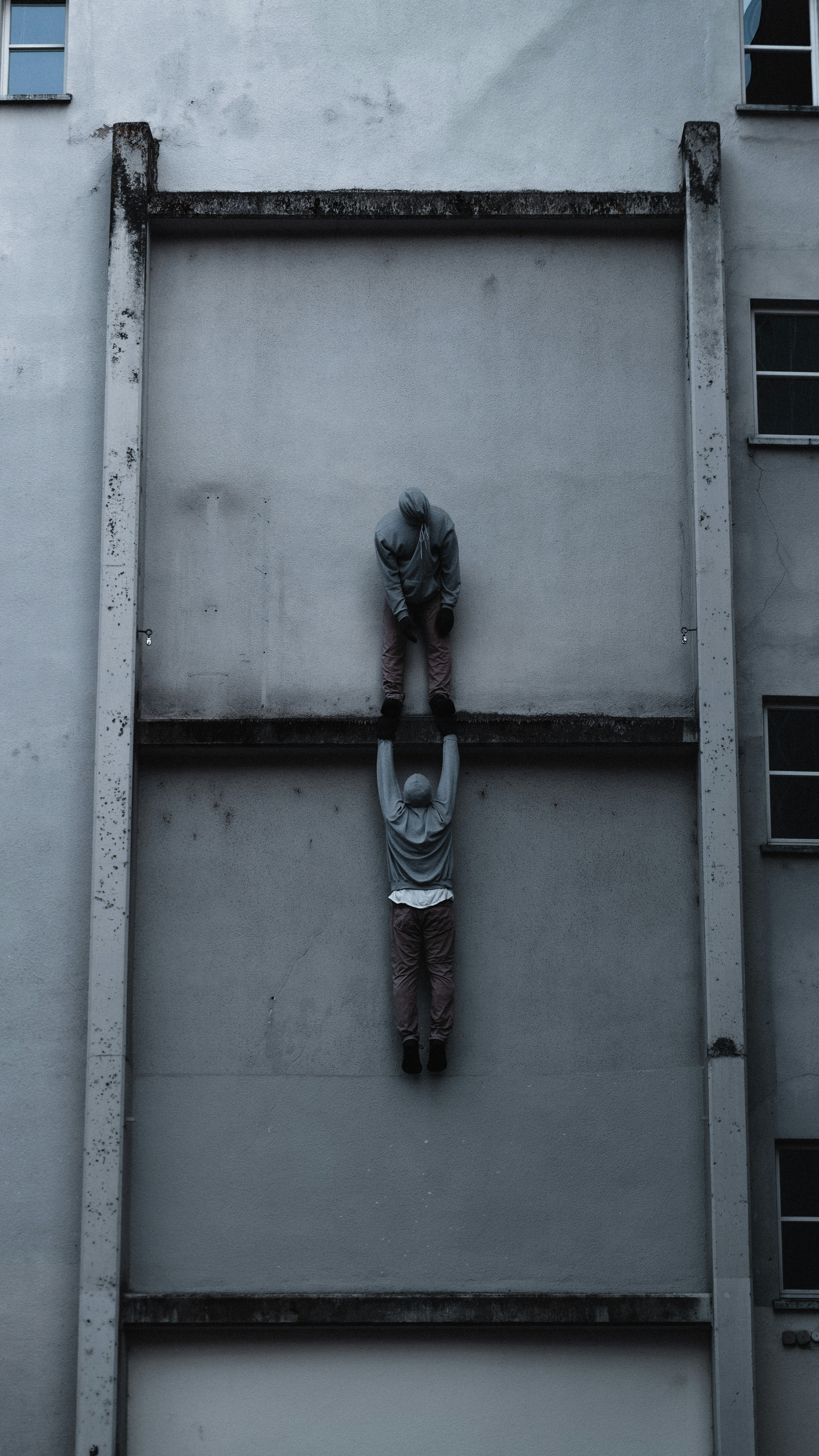 Hands Up, Walls Down: A Vertical Duo on a Weathered Facade
