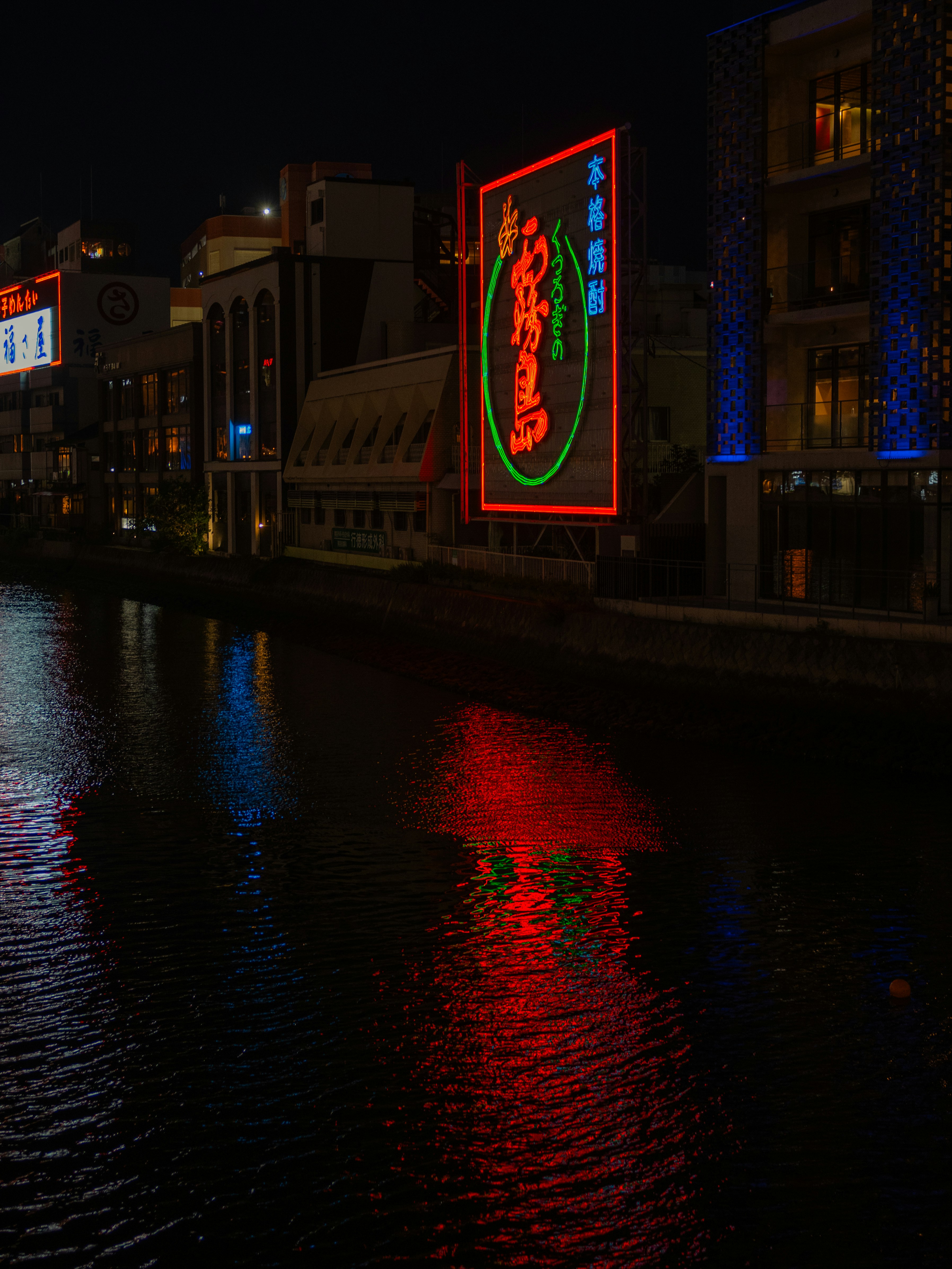 Neon signs reflect in the dark water at night. photo – Free Building ...
