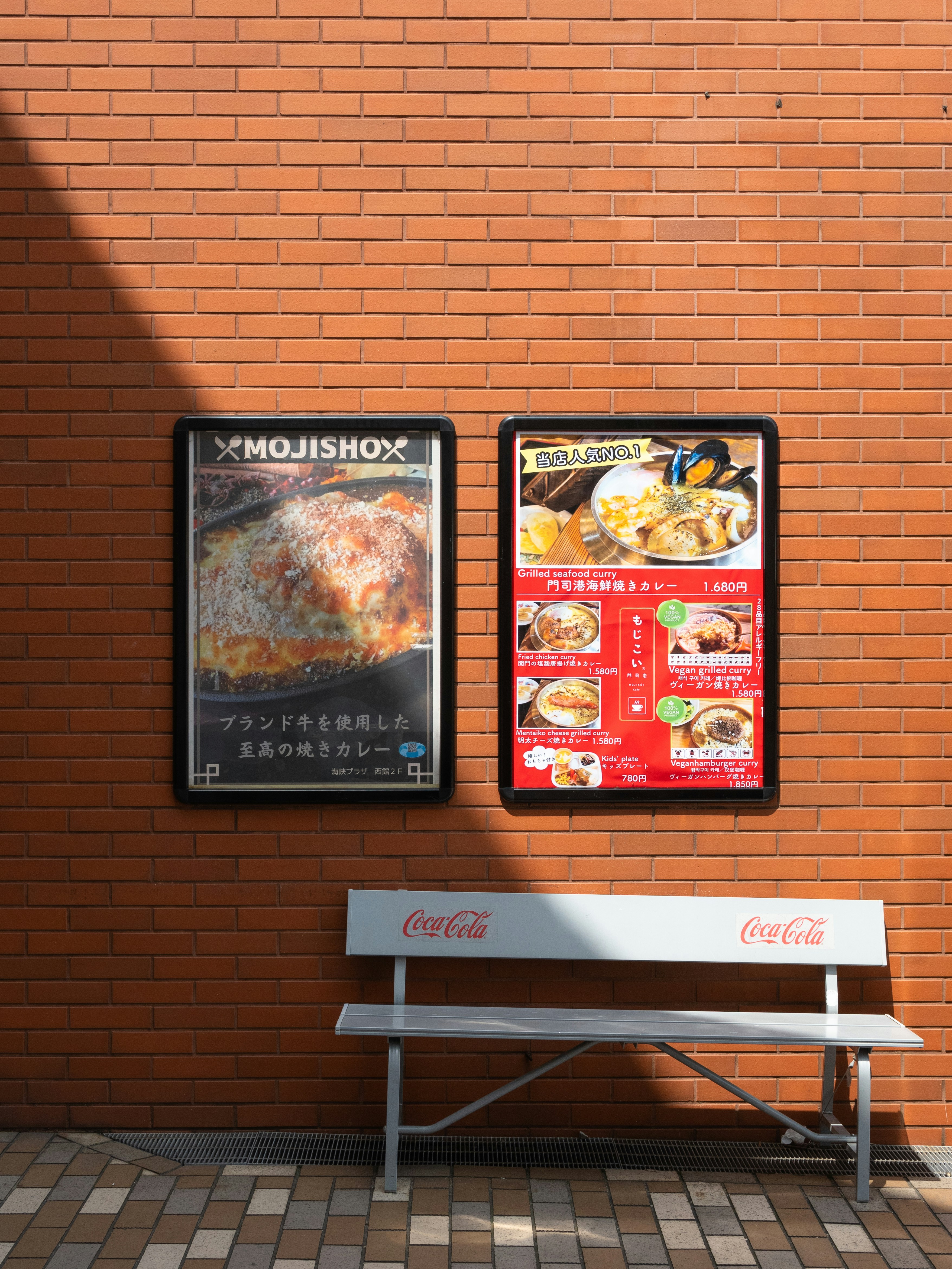 Restaurant posters are displayed next to a bench. photo – Free Green ...