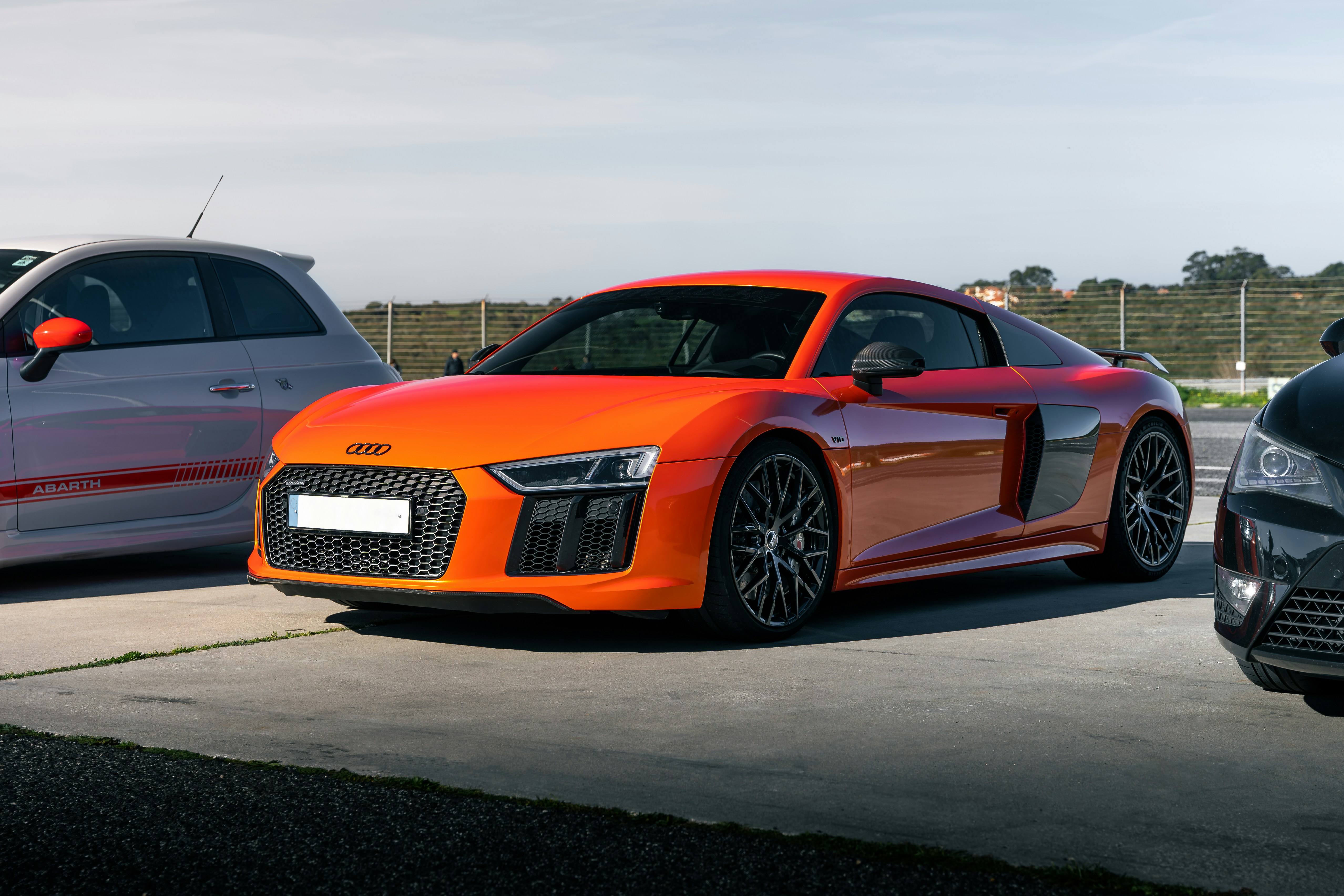 Orange audi r8 sits with other cars. photo – Free Sports car Image on ...
